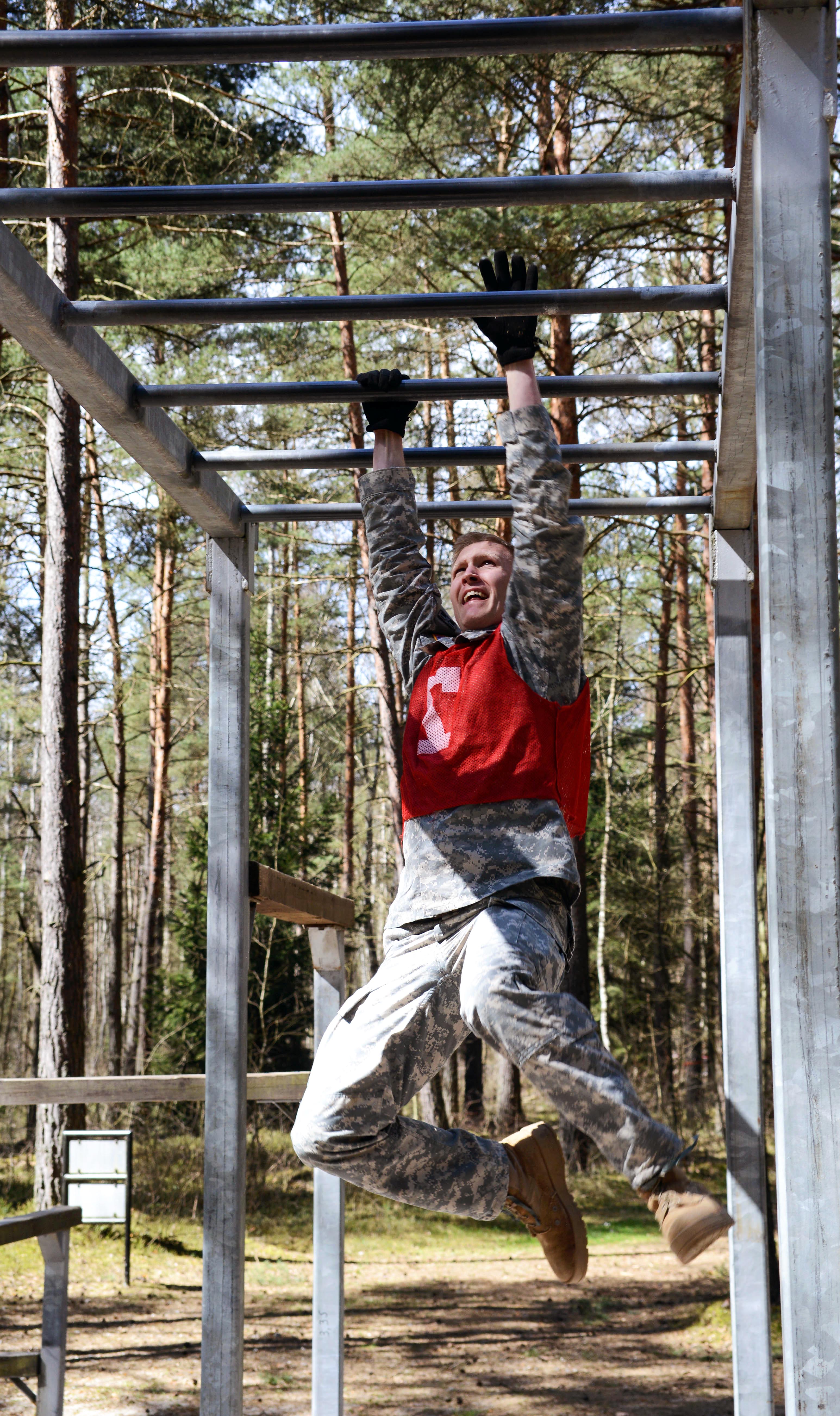 U.S. Army Staff Sgt. Larry Splane navigates a horizontal ladder ...