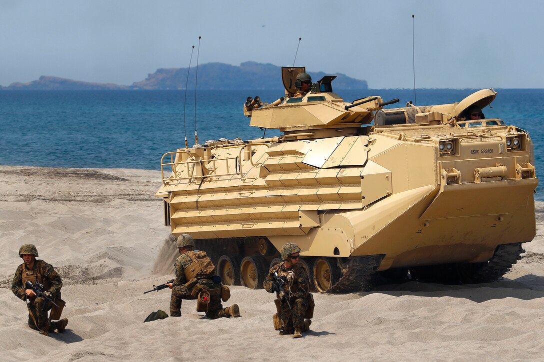 U.S. Marines post security as an amphibious assault vehicle carrying U ...