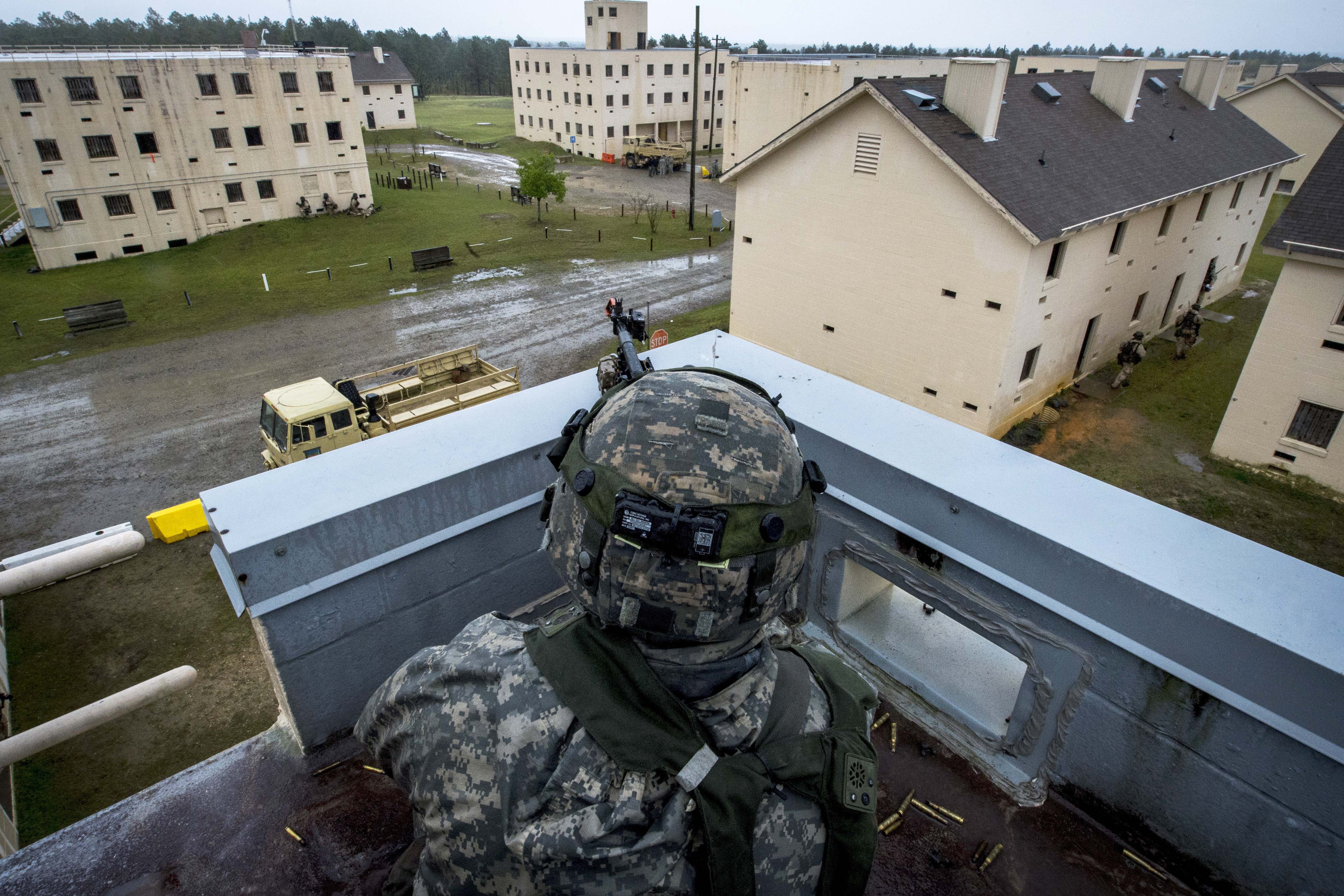 A U.S. soldier provides security from the roof of a building during an ...