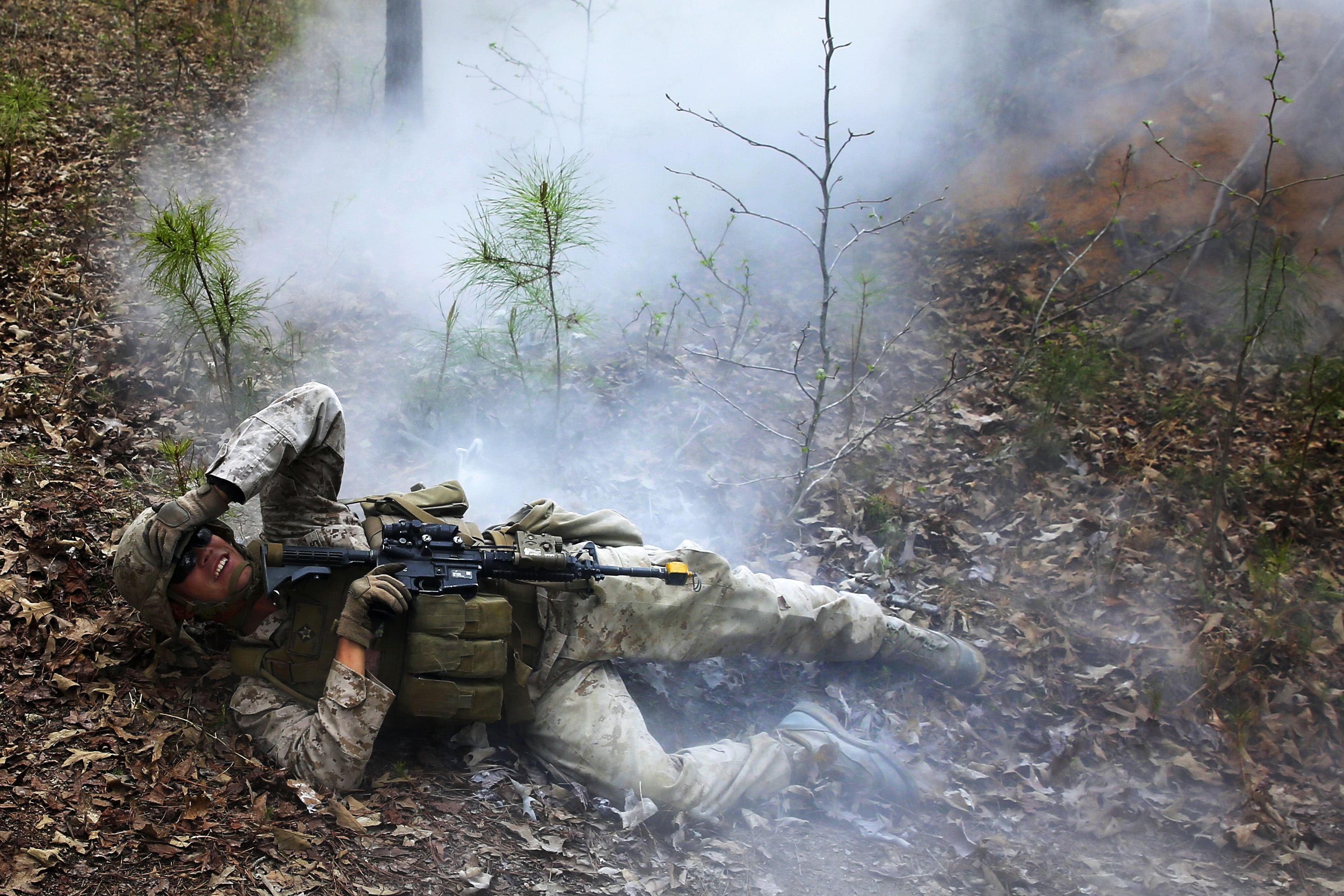 A Marine portrays a simulated casualty after the detonation of a mock ...