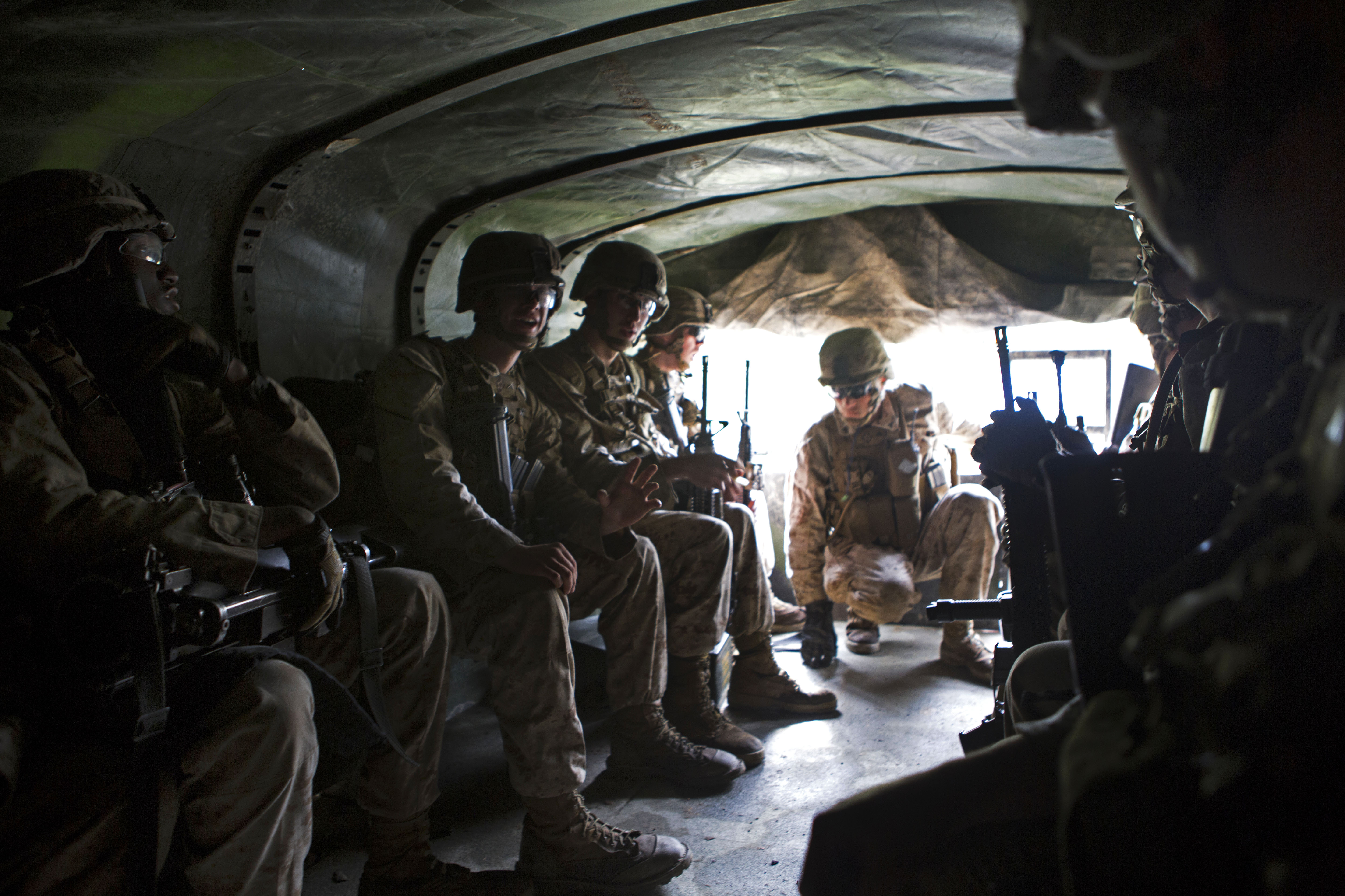 Marines sit in the back of a 7-ton truck before being transported to a ...