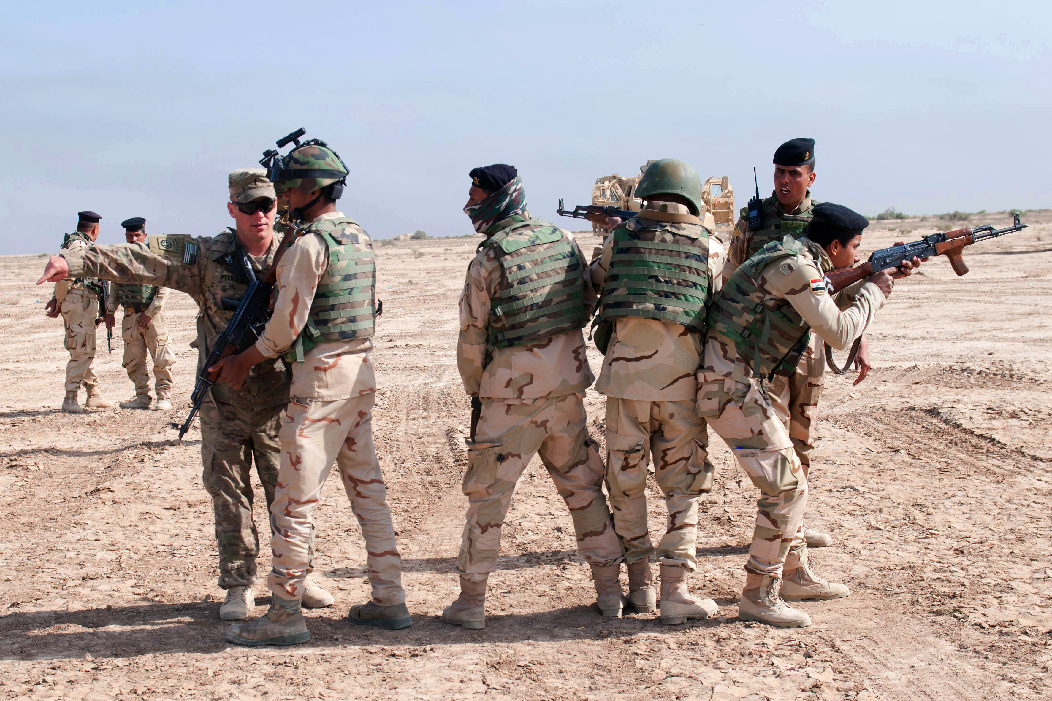 A U.S. soldier instructs Iraqi army soldiers during a mounted breach ...