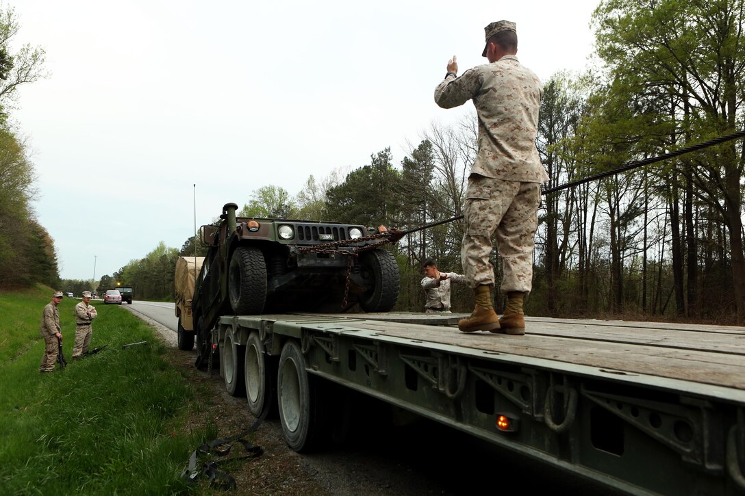Marine Corps Staff Sgt. Michael Moore, right, ground guides a Humvee ...