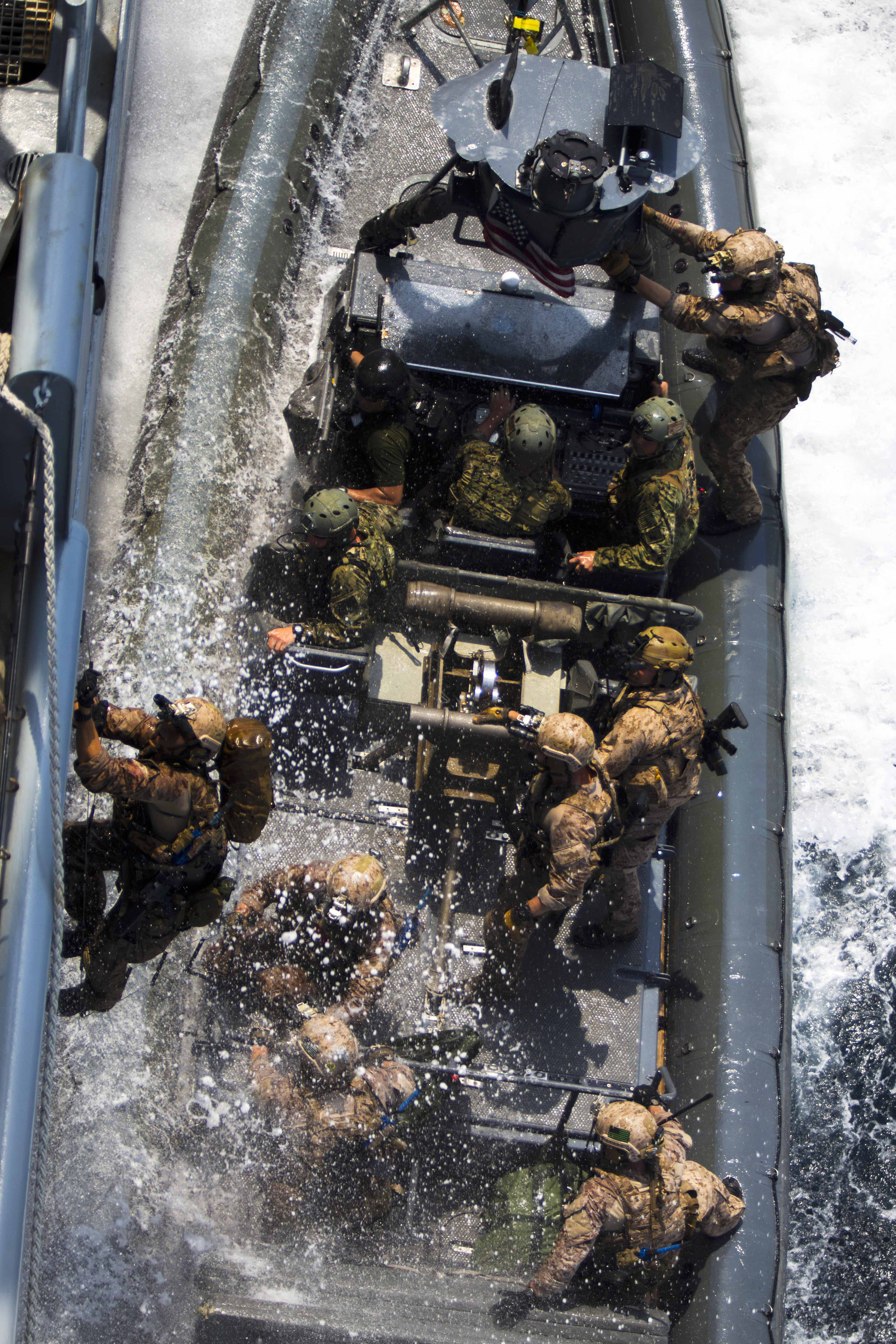 U.S. Navy SEALs and Marines prepare to board a ship from a rigid-hull ...