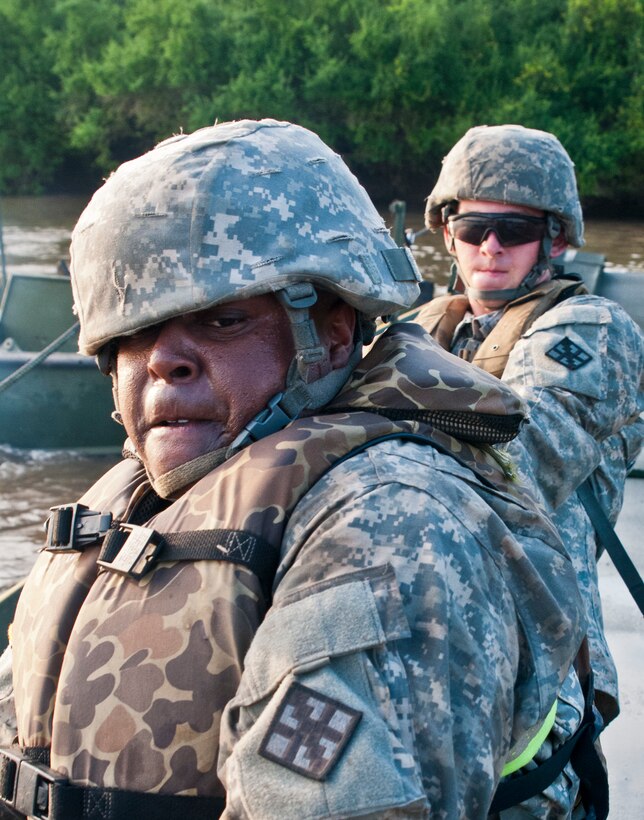 U.S. Army Spc. Calvin Hoggard strains to pull parts of an Improved ...