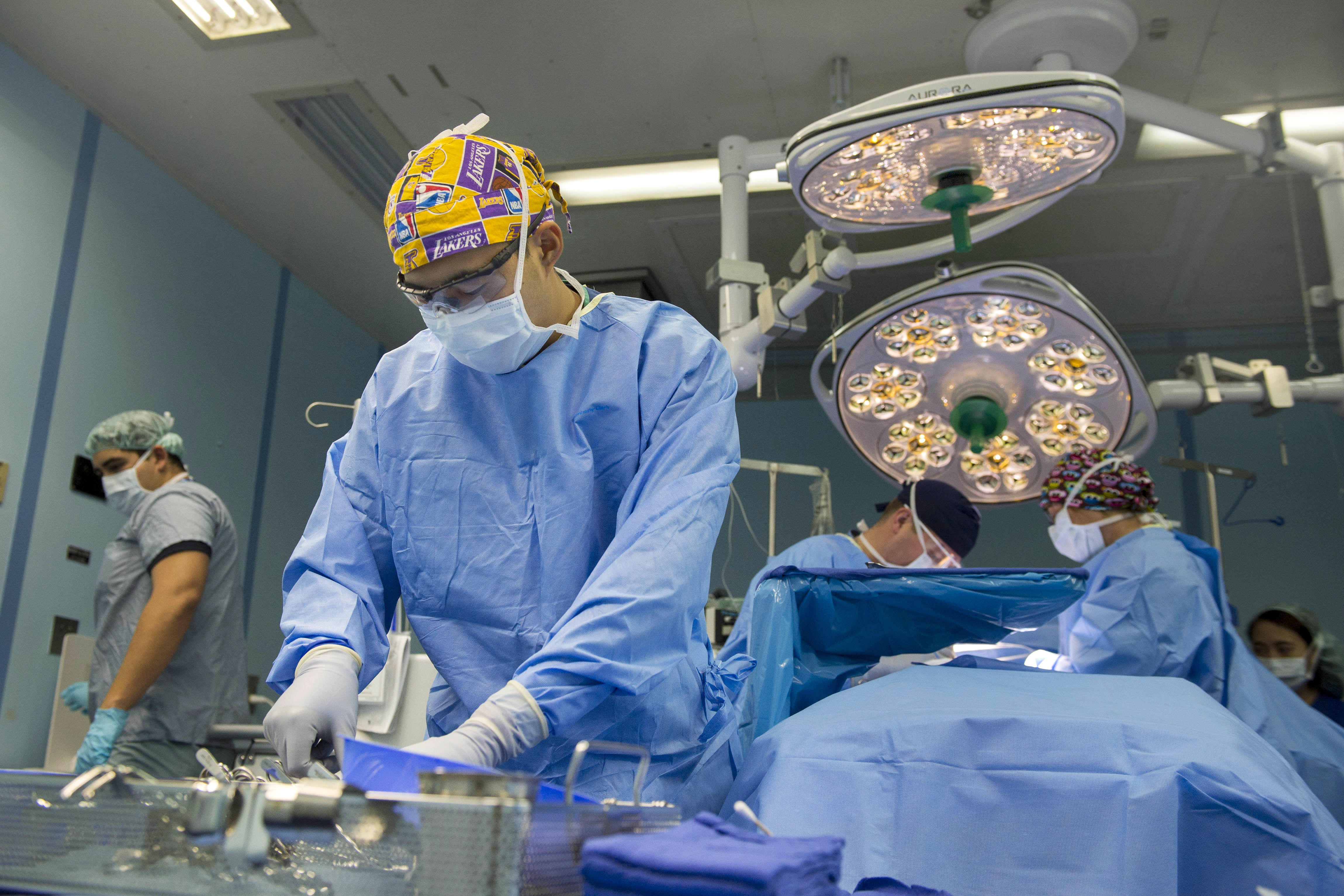 U.S. Navy Petty Officer 3rd Class Andrew Kim, center, manages surgical ...