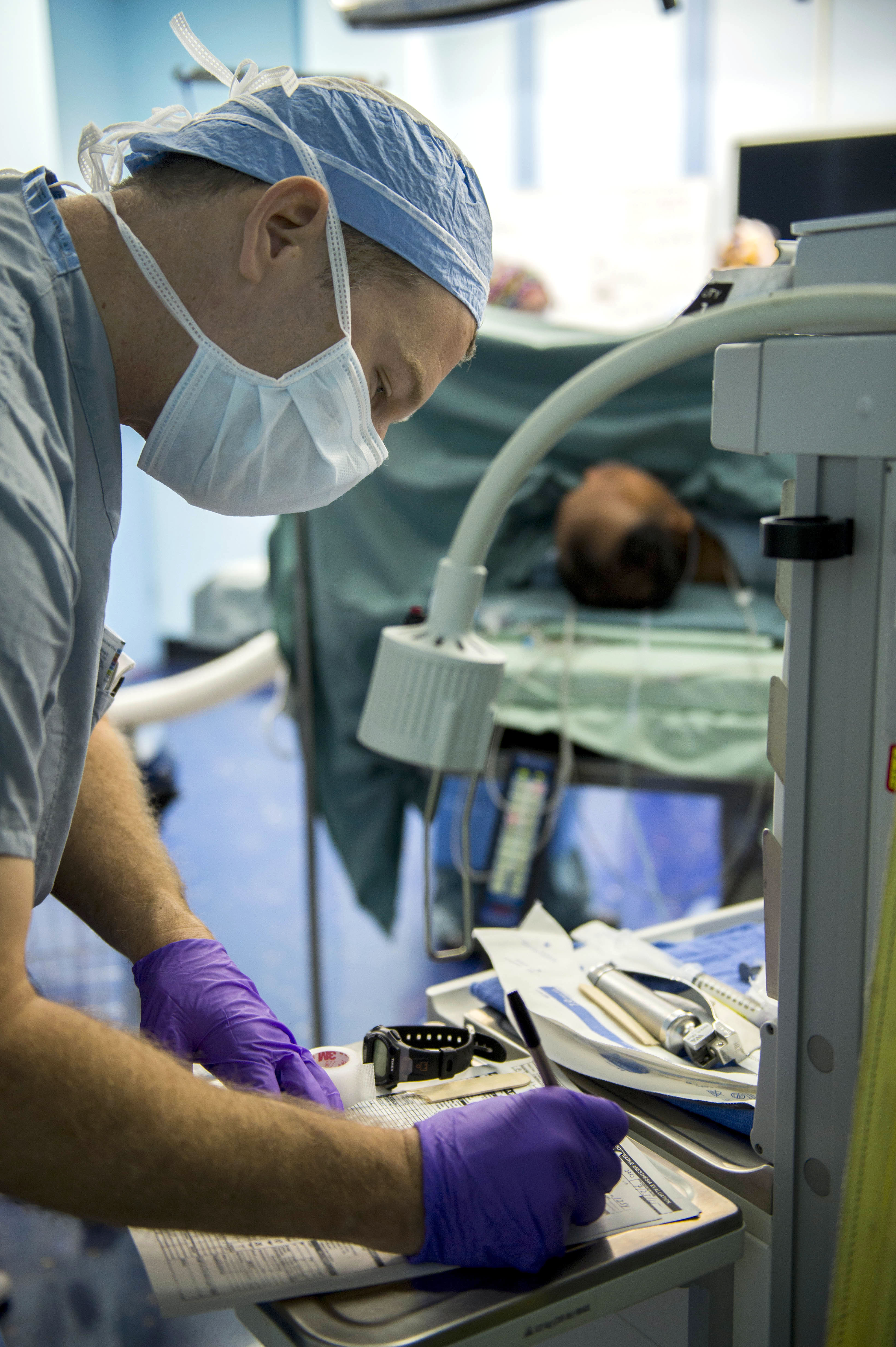 U.S. Navy Lt. Cmdr. Brian Terrien records medical data on a Filipino ...