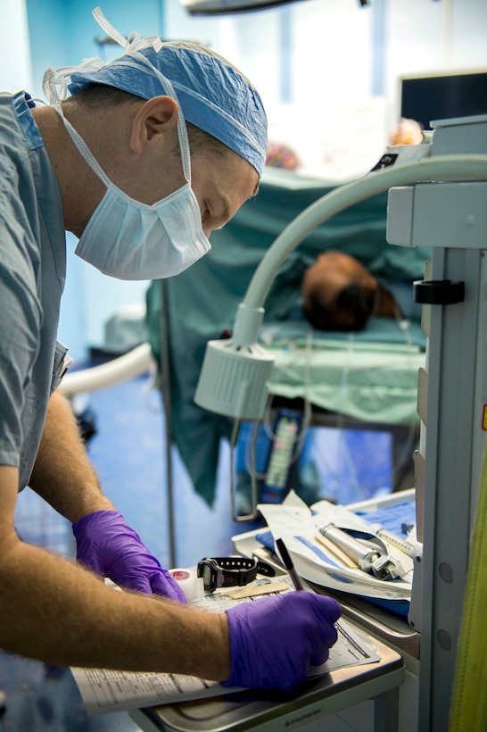 U.S. Navy Lt. Cmdr. Brian Terrien records medical data on a Filipino ...