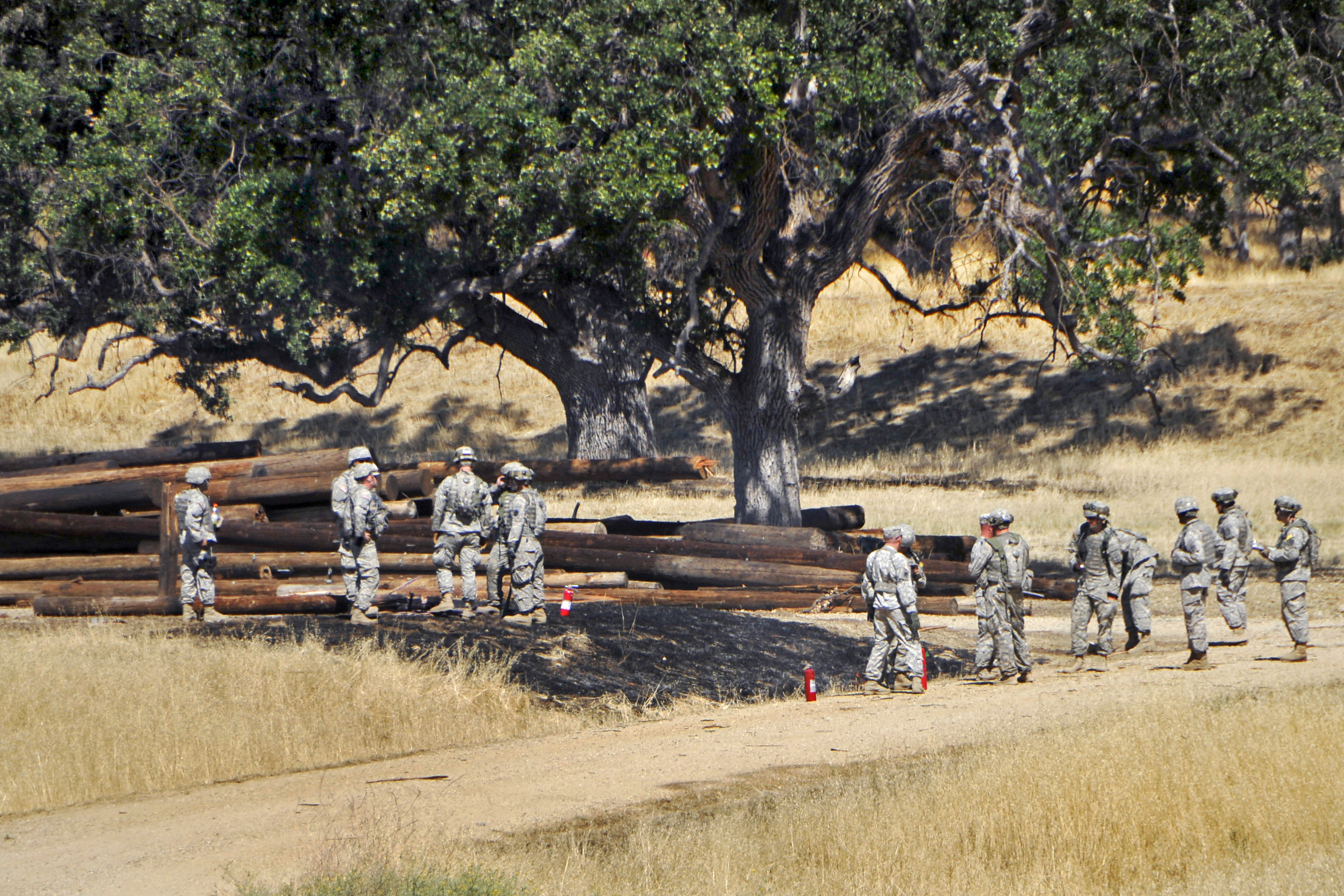 Army Reservists gather after extinguishing a small fire caused by ...