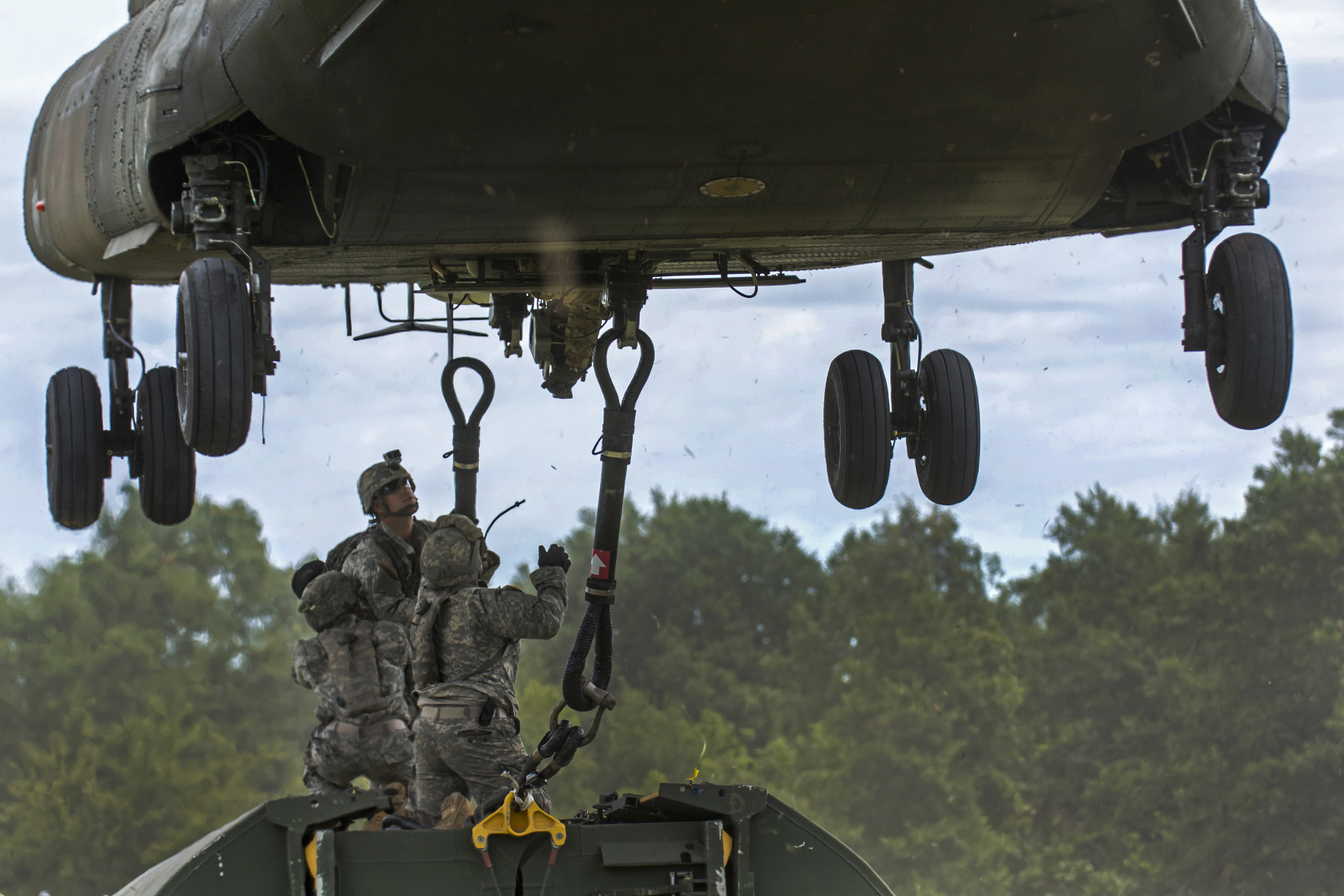 Army Reservists hook a bay bridge to a CH-47 Chinook helicopter using a ...