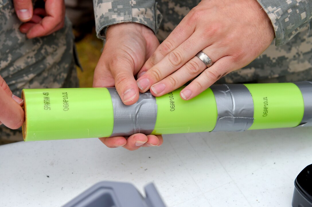 Soldiers secure explosive charges with duct tape while constructing an ...