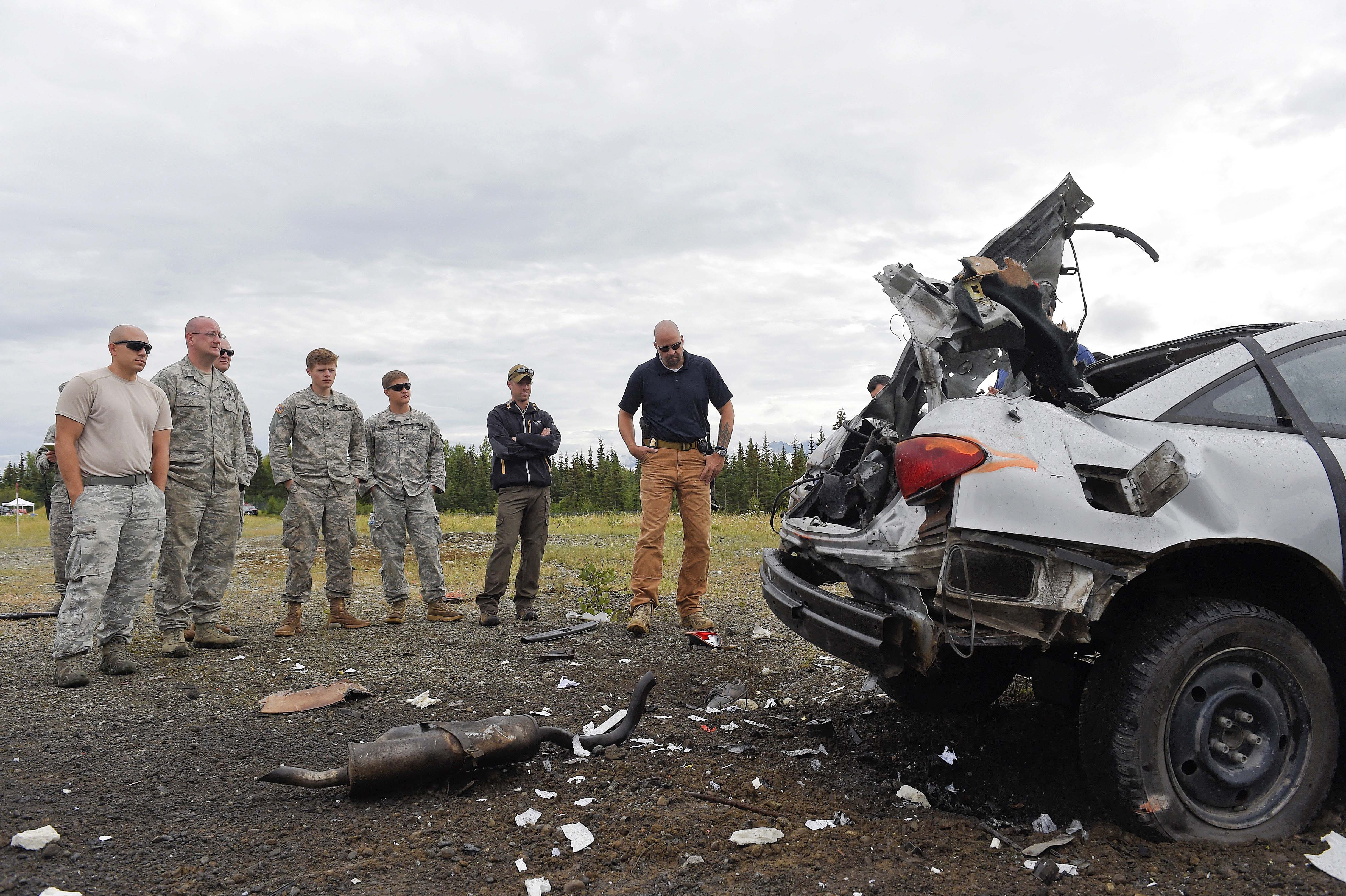 Airmen and soldiers examine the results of a controlled detonation with ...