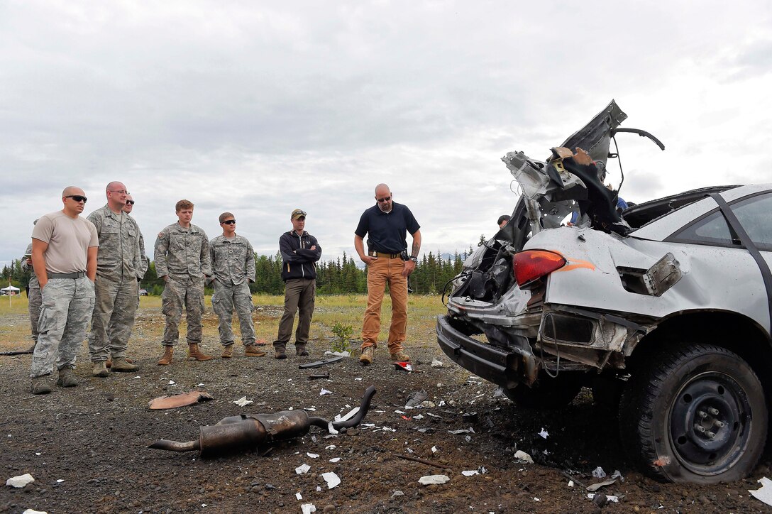 Airmen and soldiers examine the results of a controlled detonation with ...