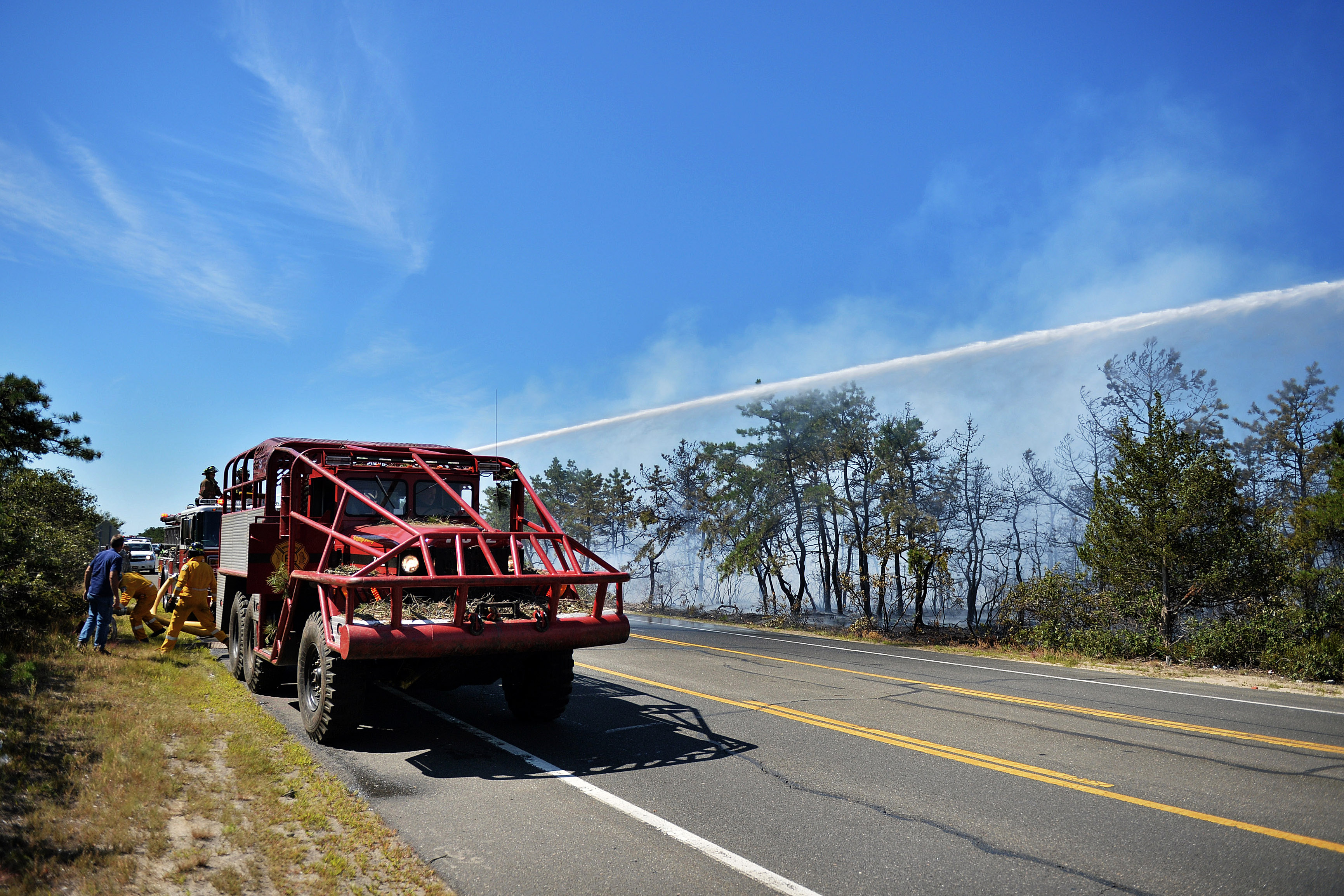 Airmen and Westhampton Fire Department responders direct water at a ...
