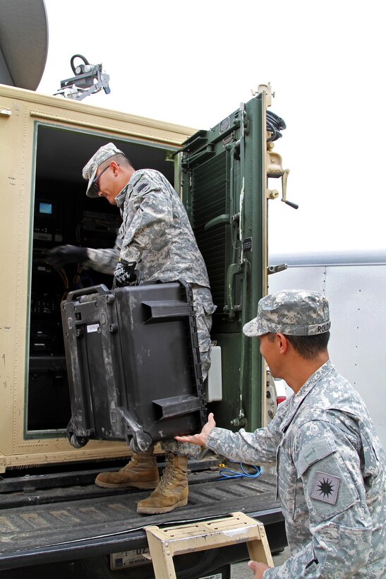 Army Sgts. Tien Quach, left, and Jason Roldan load equipment into an ...
