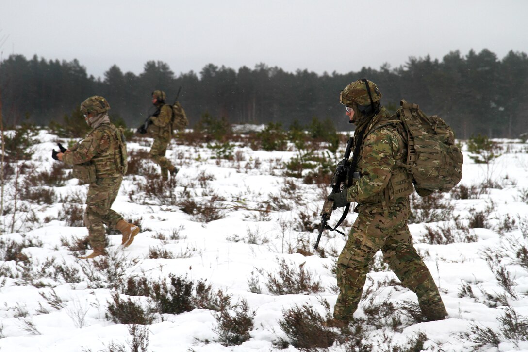 U.S. soldiers move out in an open field during a squad training ...