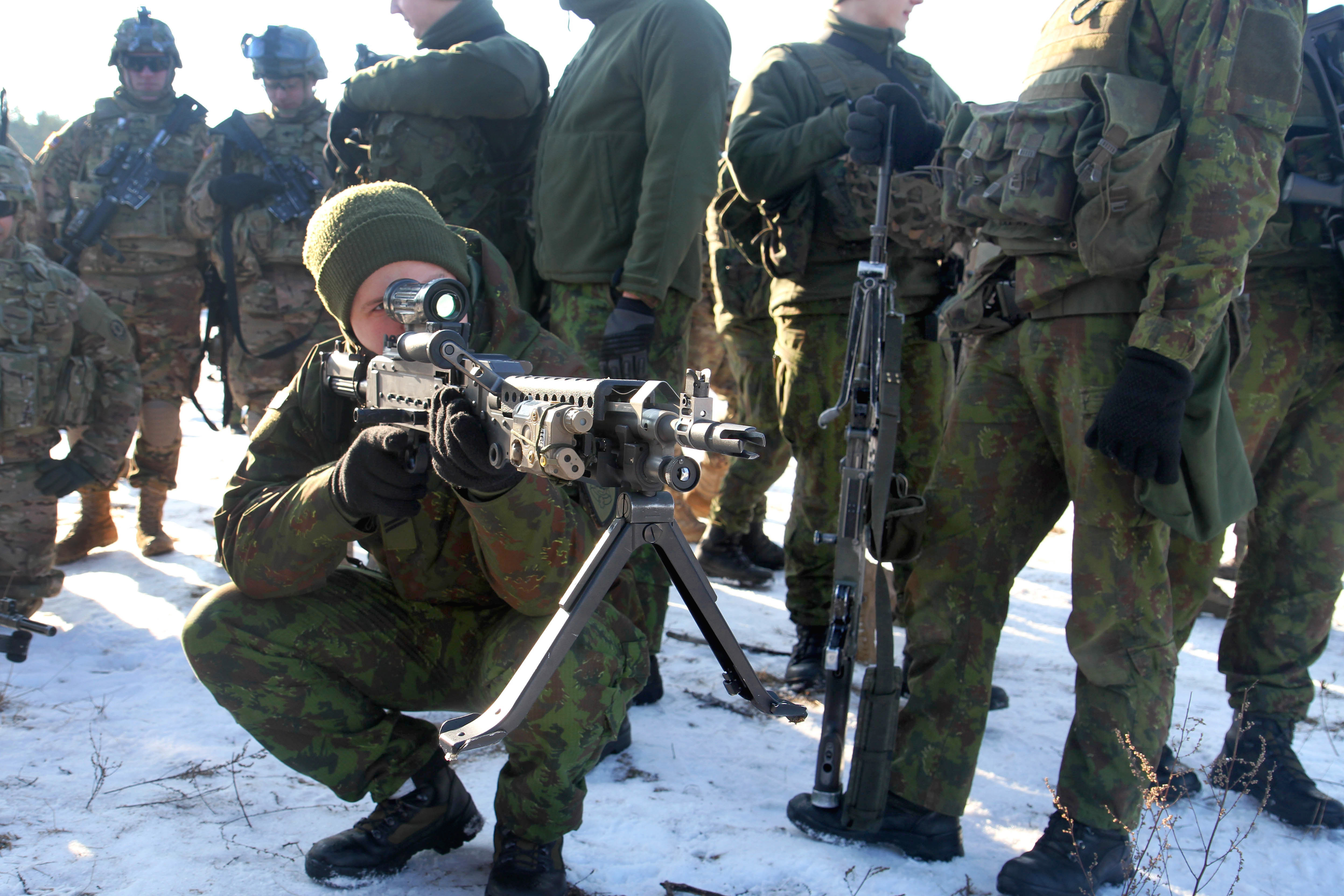A Lithuanian soldier looks through the sight of a U.S. machine gun ...