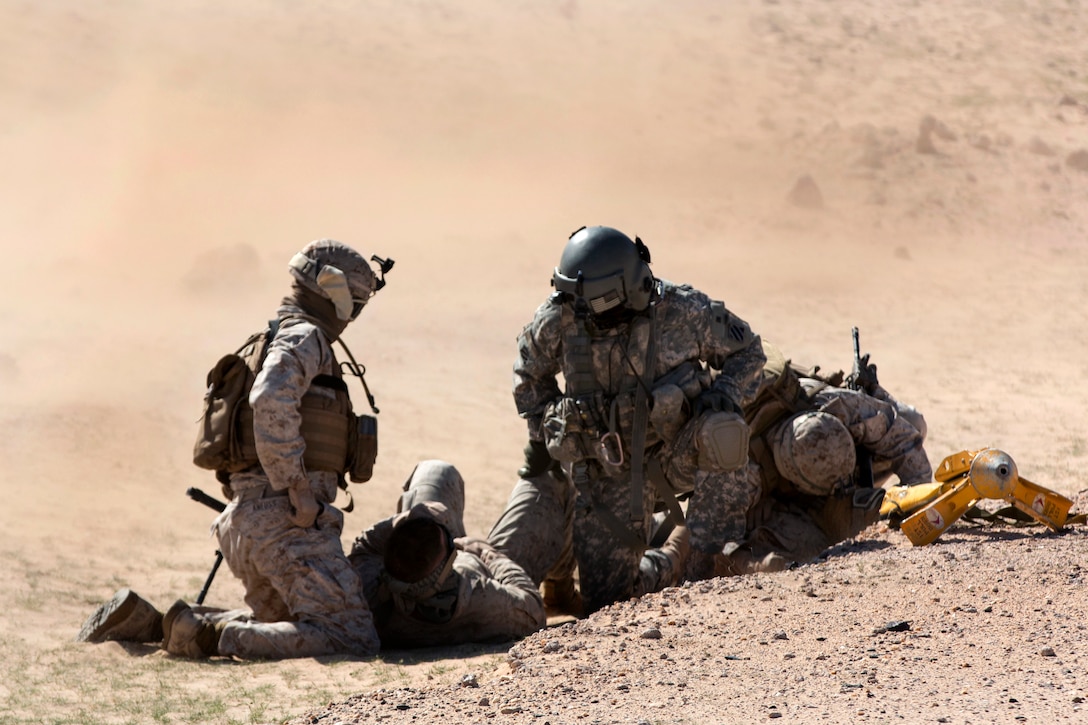 A U.S. soldier and U.S. Marine helps simulated casualties during a ...