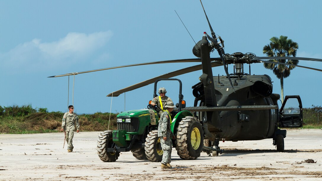 U.S. Army soldiers tow a Black Hawk helicopter to a staging area to ...