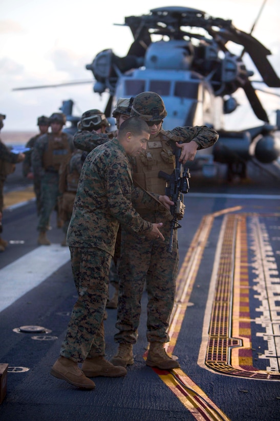 U.S. Marines perform a safety check on a weapon after conducting a live ...