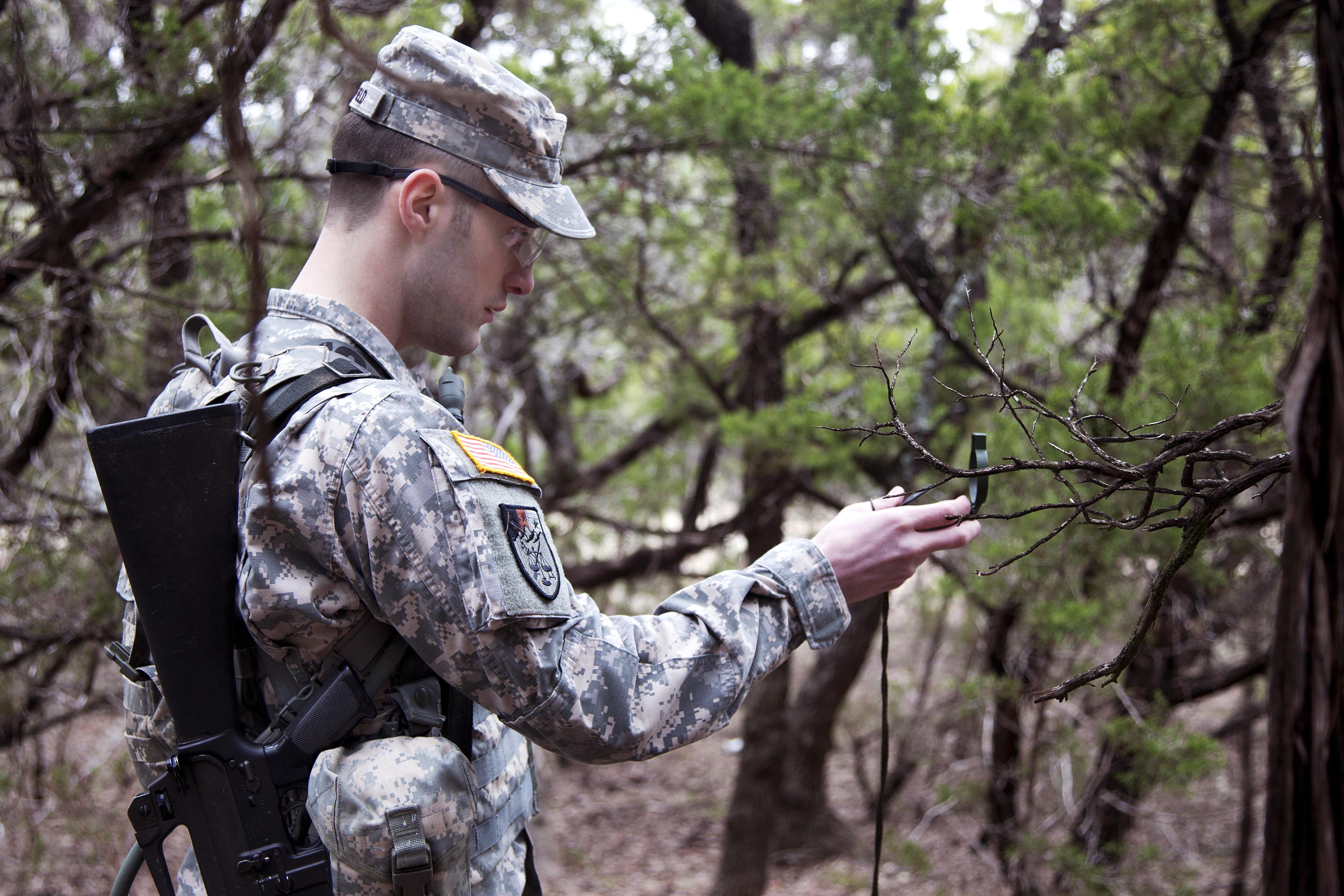 Army Staff Sgt. Jordan Stubblefield uses a lensatic compass to shoot an ...