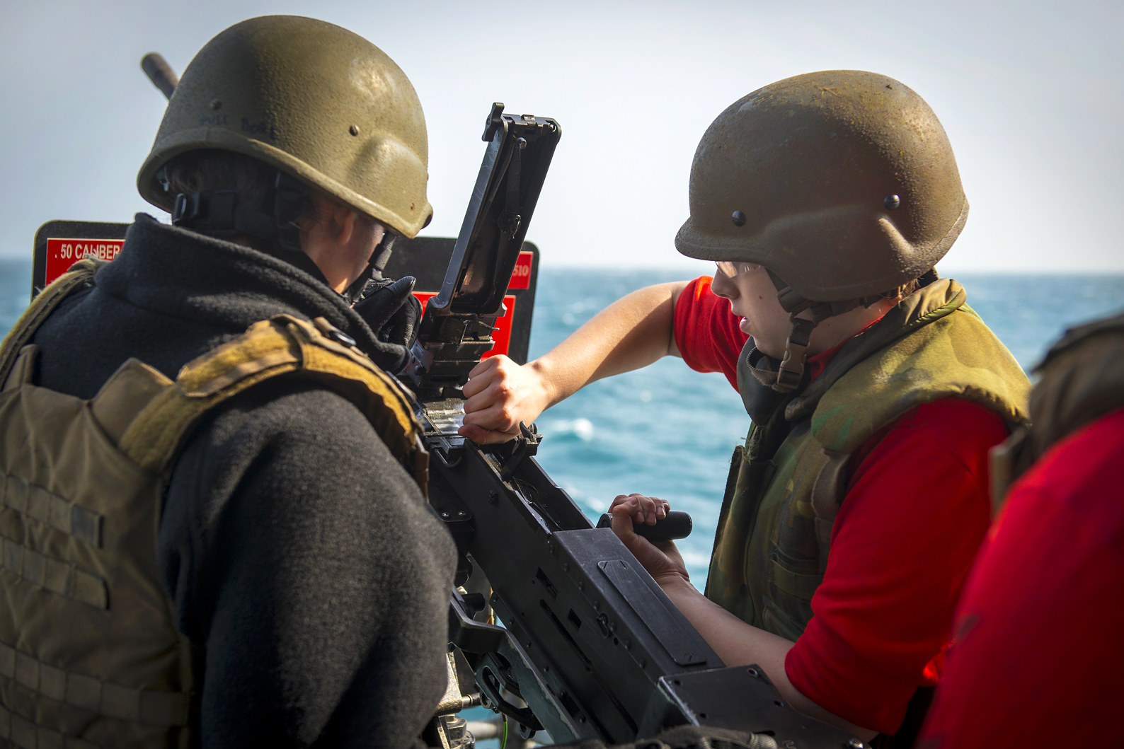 U.S. Navy Seaman Kristen Neufeld, right, checks the headspace and ...