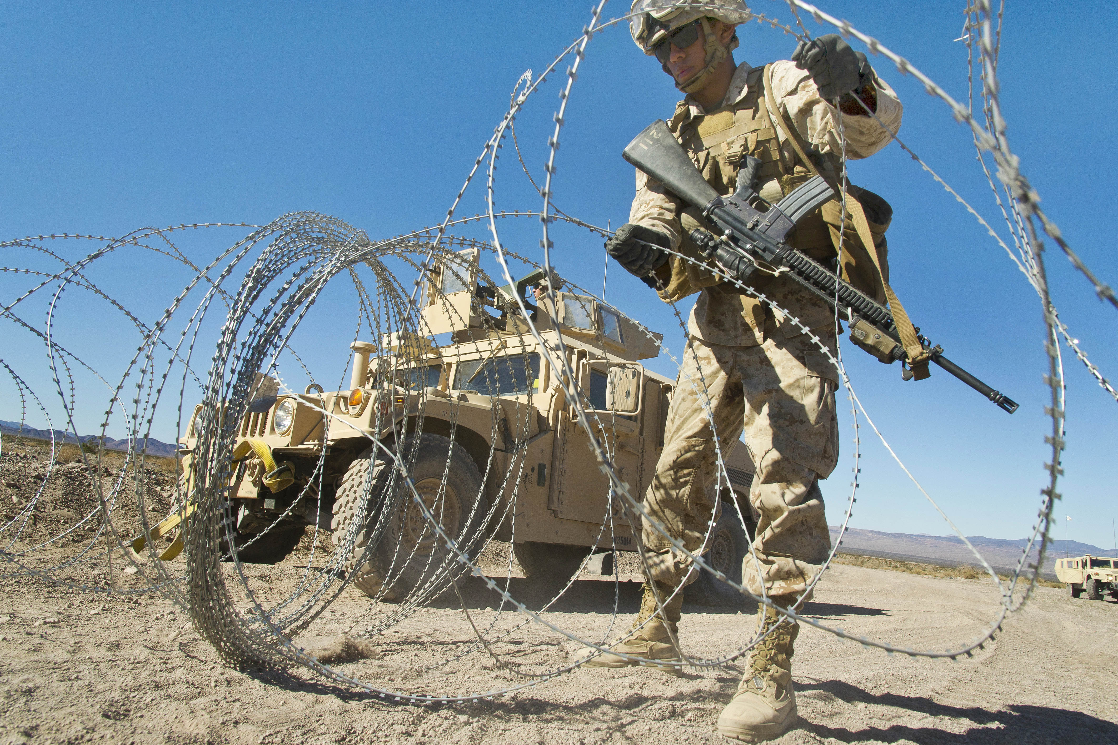 Marine Corps Lance Cpl. Christian Garcia uncoils concertina wire while ...