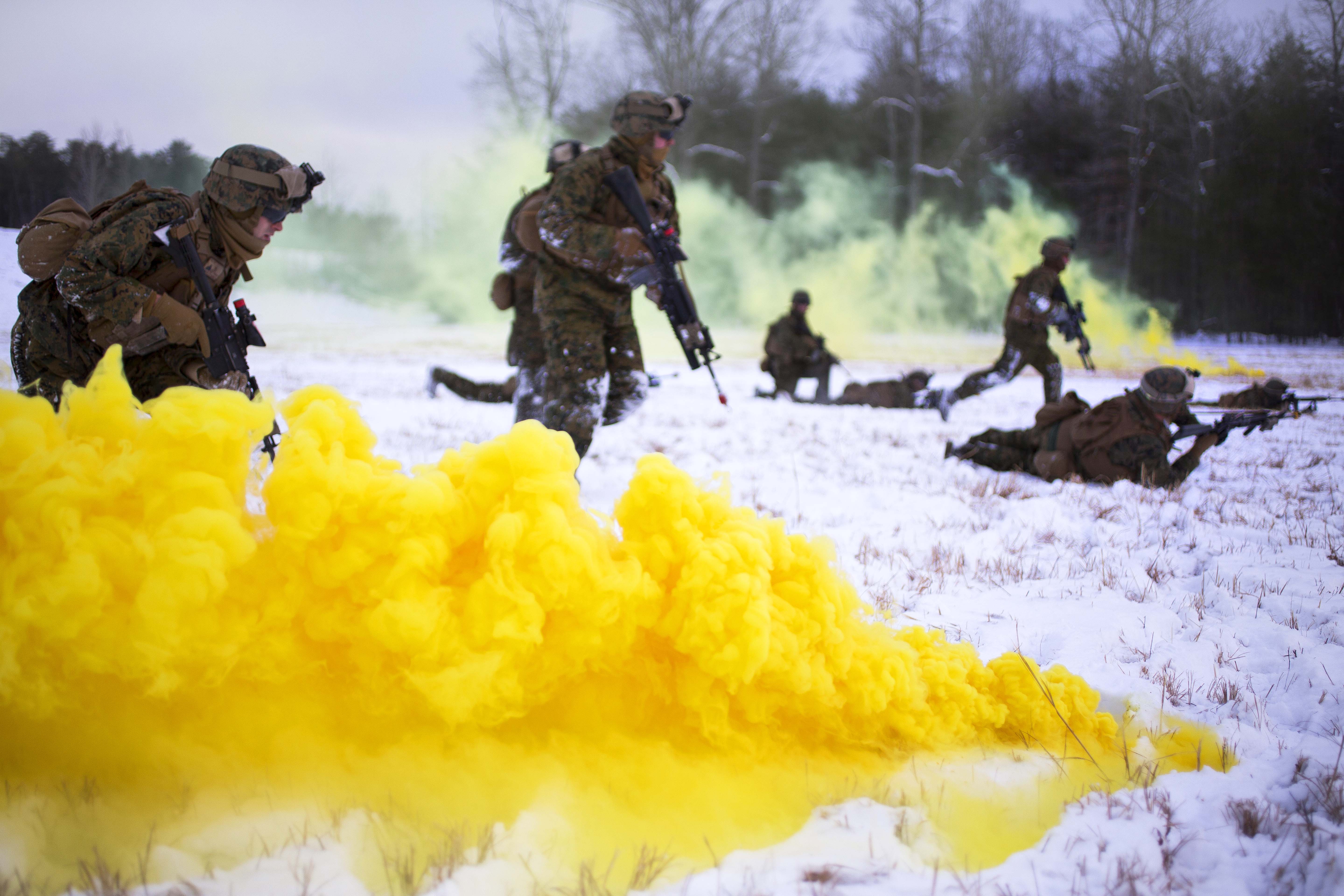 Marines conduct a fire and maneuver drill under the cover of yellow ...