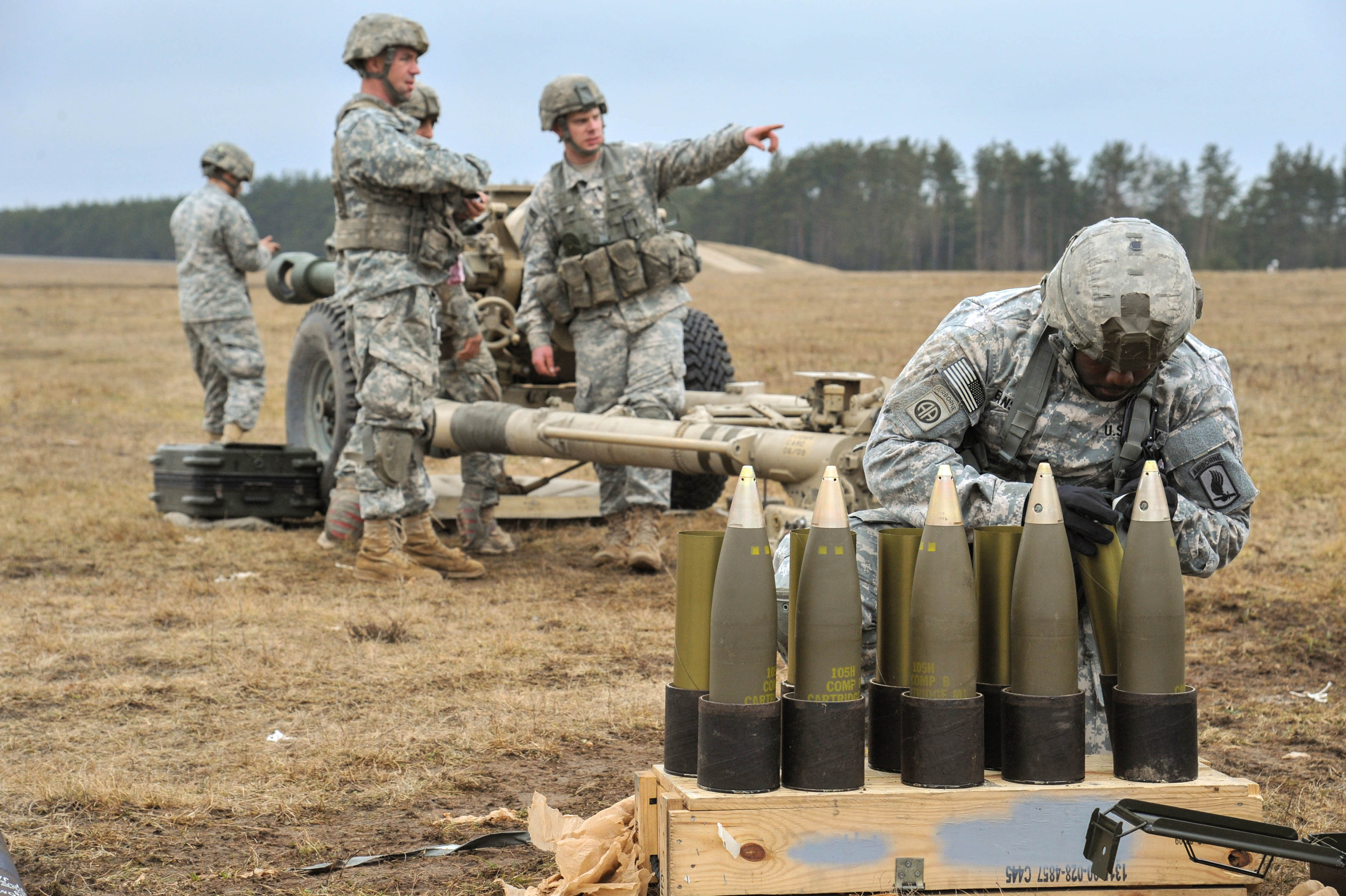 U.S. Army paratroopers get an M119 howitzer ready for combat during a heavy drop mission on the ...