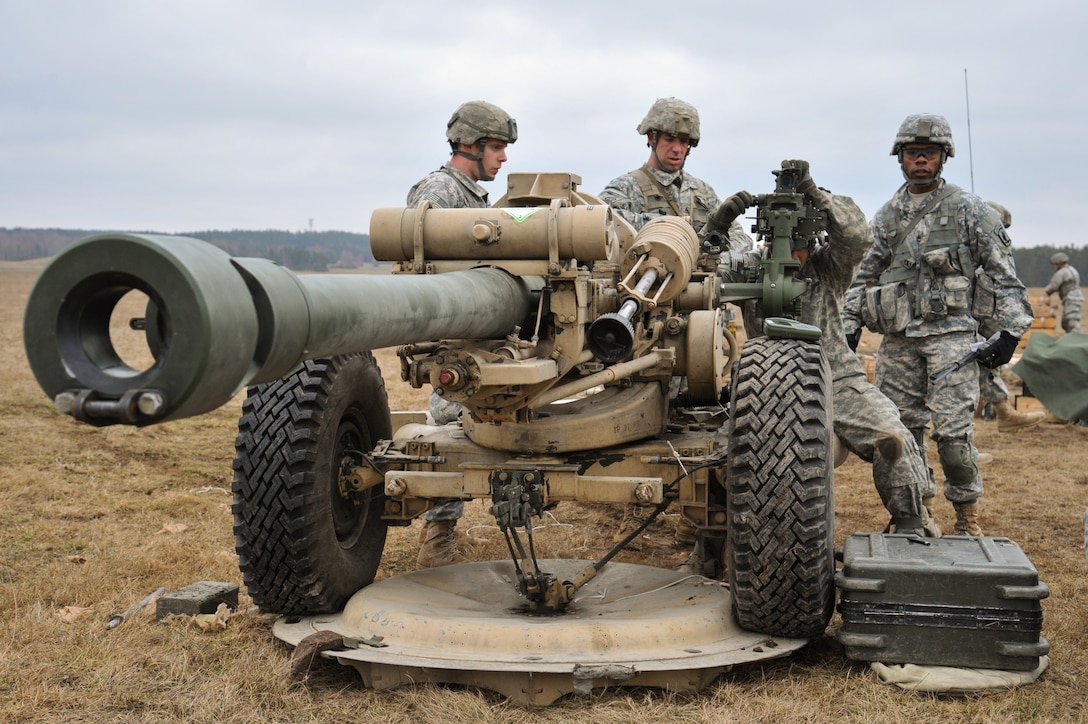 U.S. Army paratroopers get an M119 howitzer ready for combat during a ...