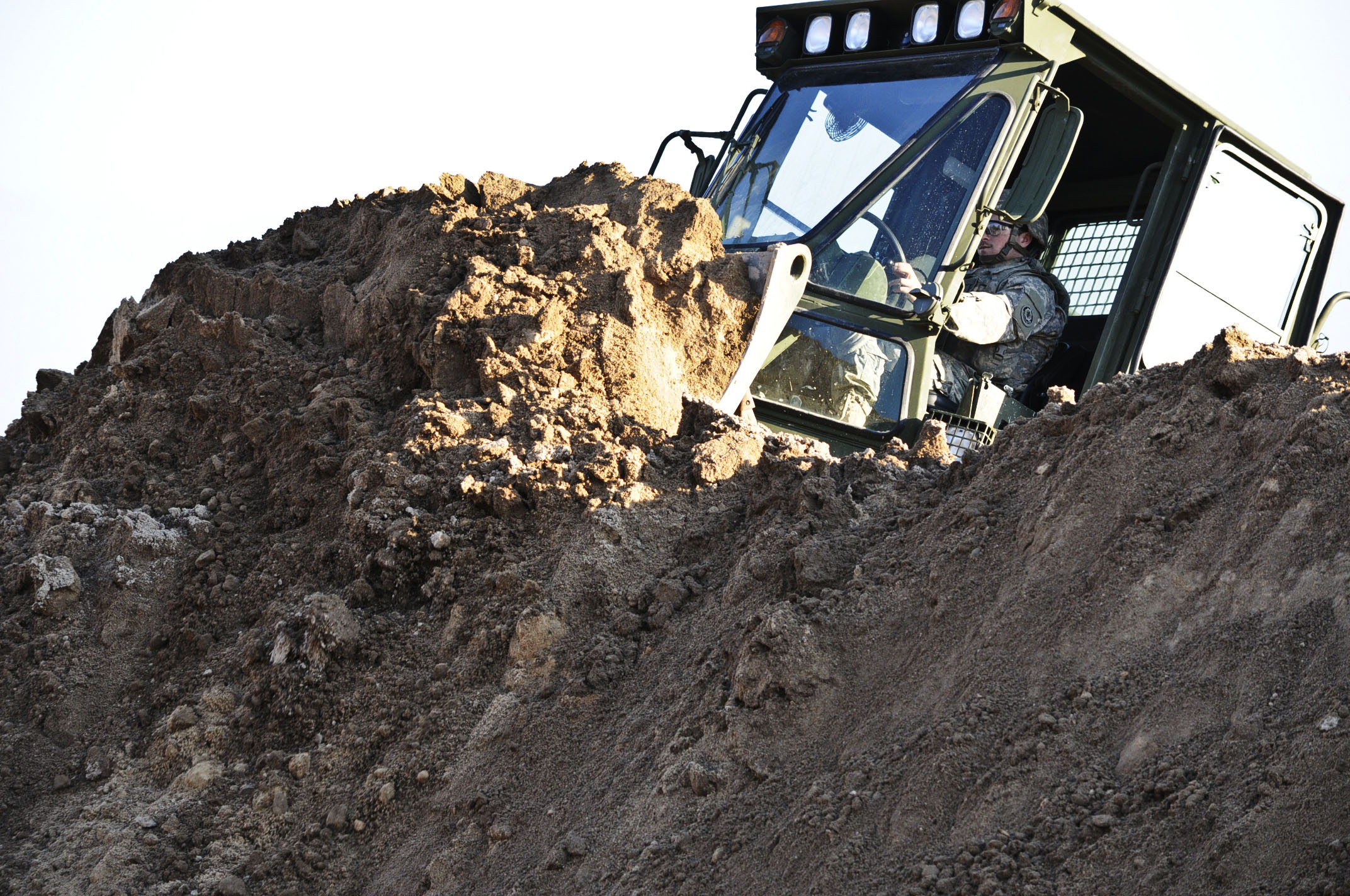 A U.S. Army soldier uses a bulldozer to move dirt during construction ...