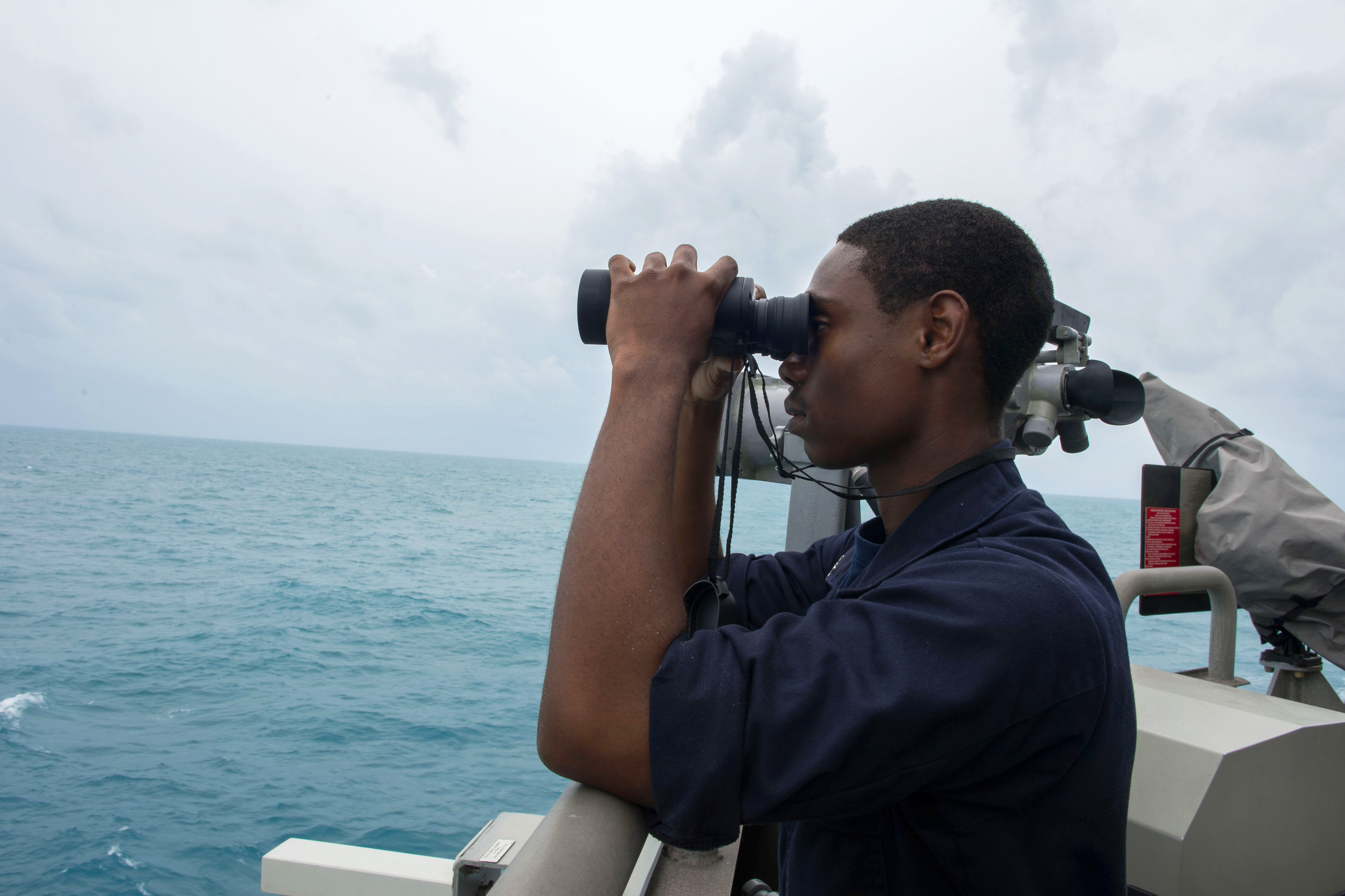 U.S. Navy Petty Officer 3rd Class Norrik Hodge stands watch on the ...