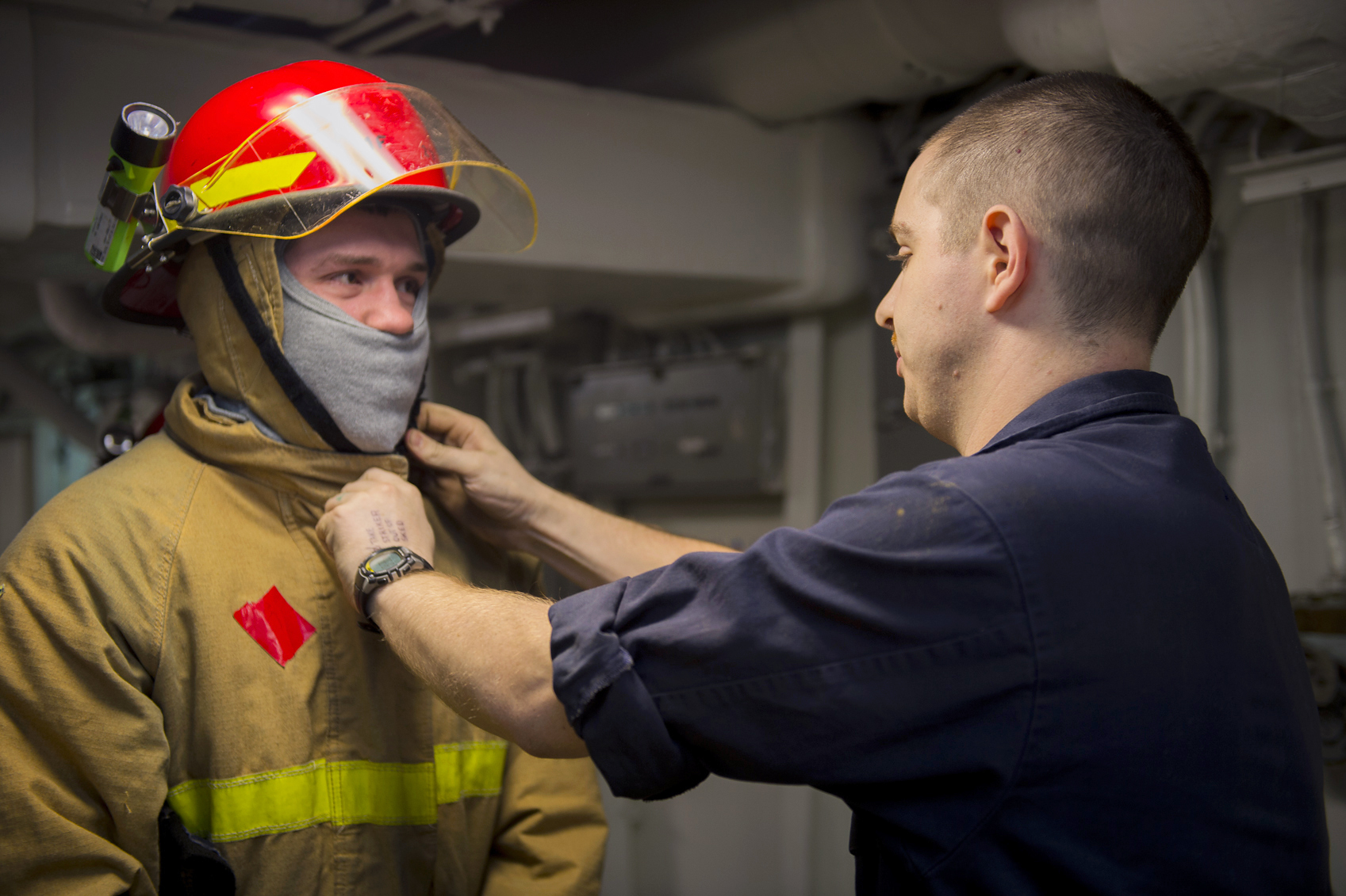 U.S. Navy Petty Officer 2nd Class Jeffrey Taylor, right, assists a ...