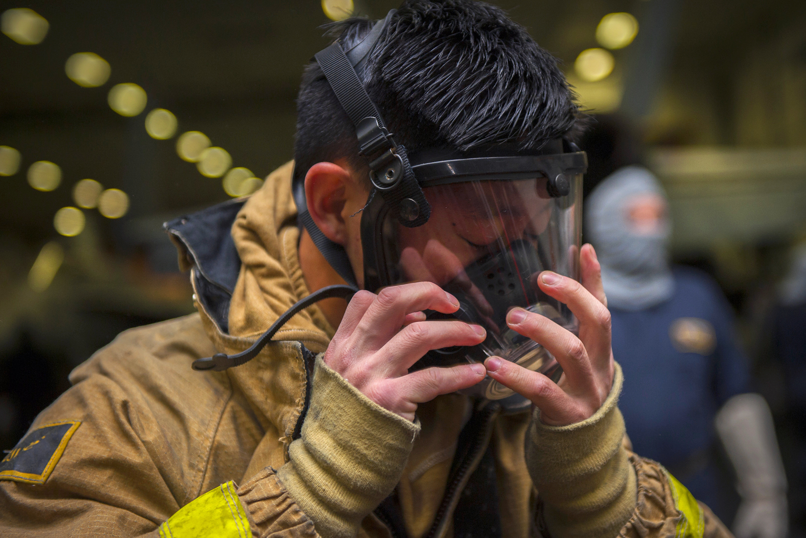 U.S. Navy Petty Officer 3rd Class Lucas Garbers dons a self-contained ...