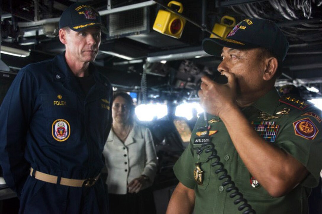 U.S. Navy Cmdr. Steven Foley, left, commander of the USS Sampson ...