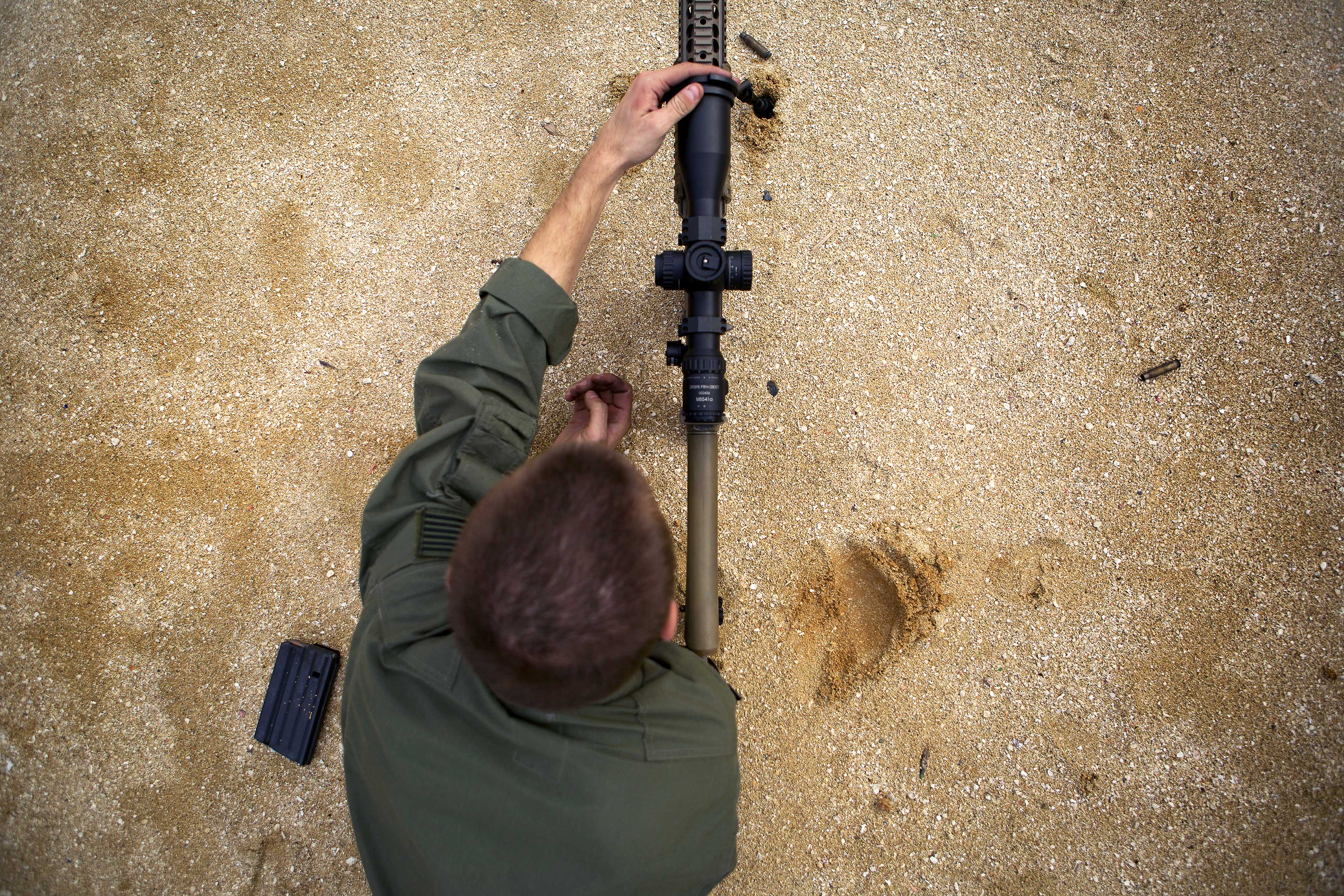 U.S. Marine Corps Cpl. Tyler Stampes gets in the prone position behind his M110 semi-automatic ...