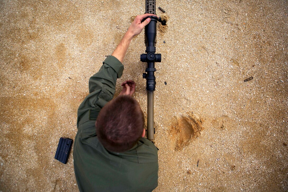 U.S. Marine Corps Cpl. Tyler Stampes gets in the prone position behind ...