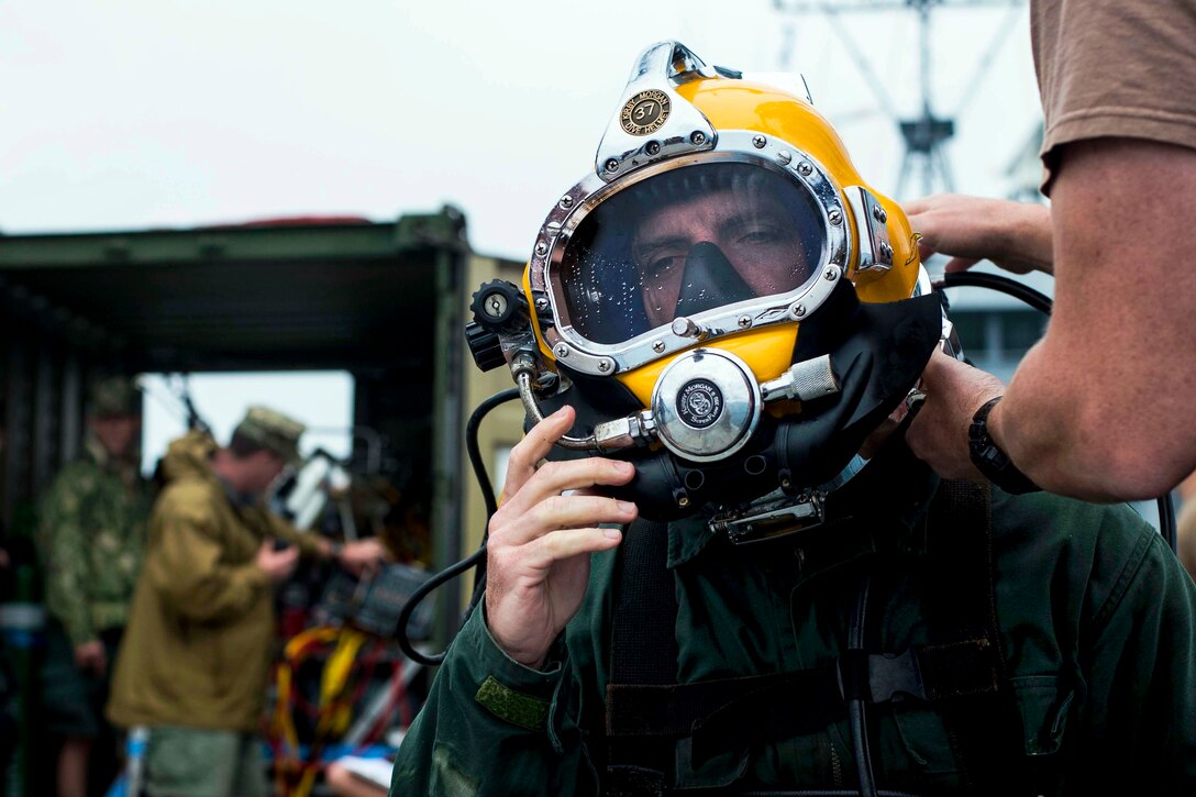 Navy Chief Petty Officer Christopher Munch dons a Kirby Morgan 37 ...
