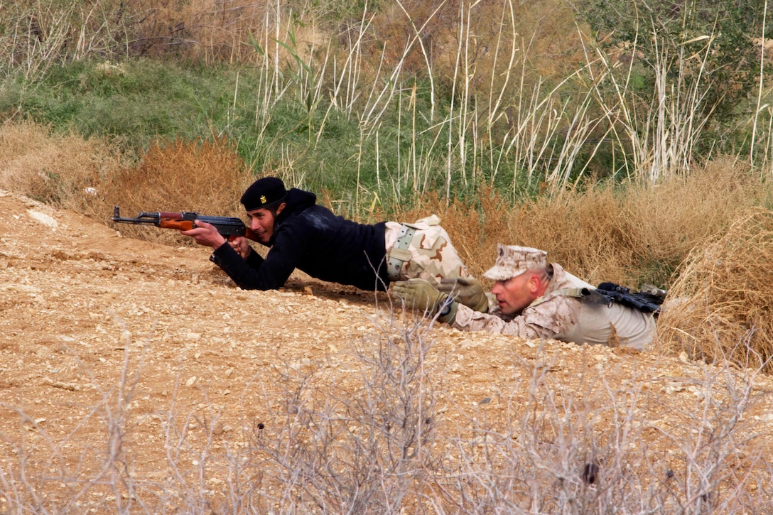 U.S. Marine Corps Maj. Matt Breen, right, helps an Iraqi army soldier ...