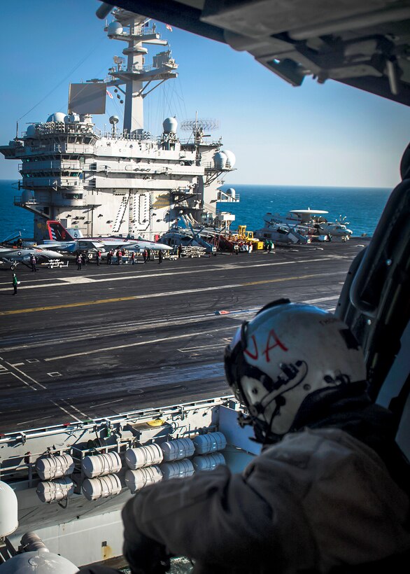 U.S. Navy Petty Officer 1st Class Christopher Thomas signals sailors ...