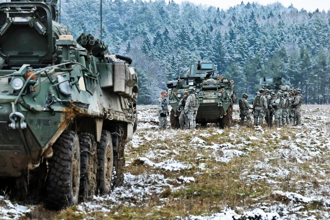 U.S. soldiers receive a mission brief before moving out on a convoy to ...