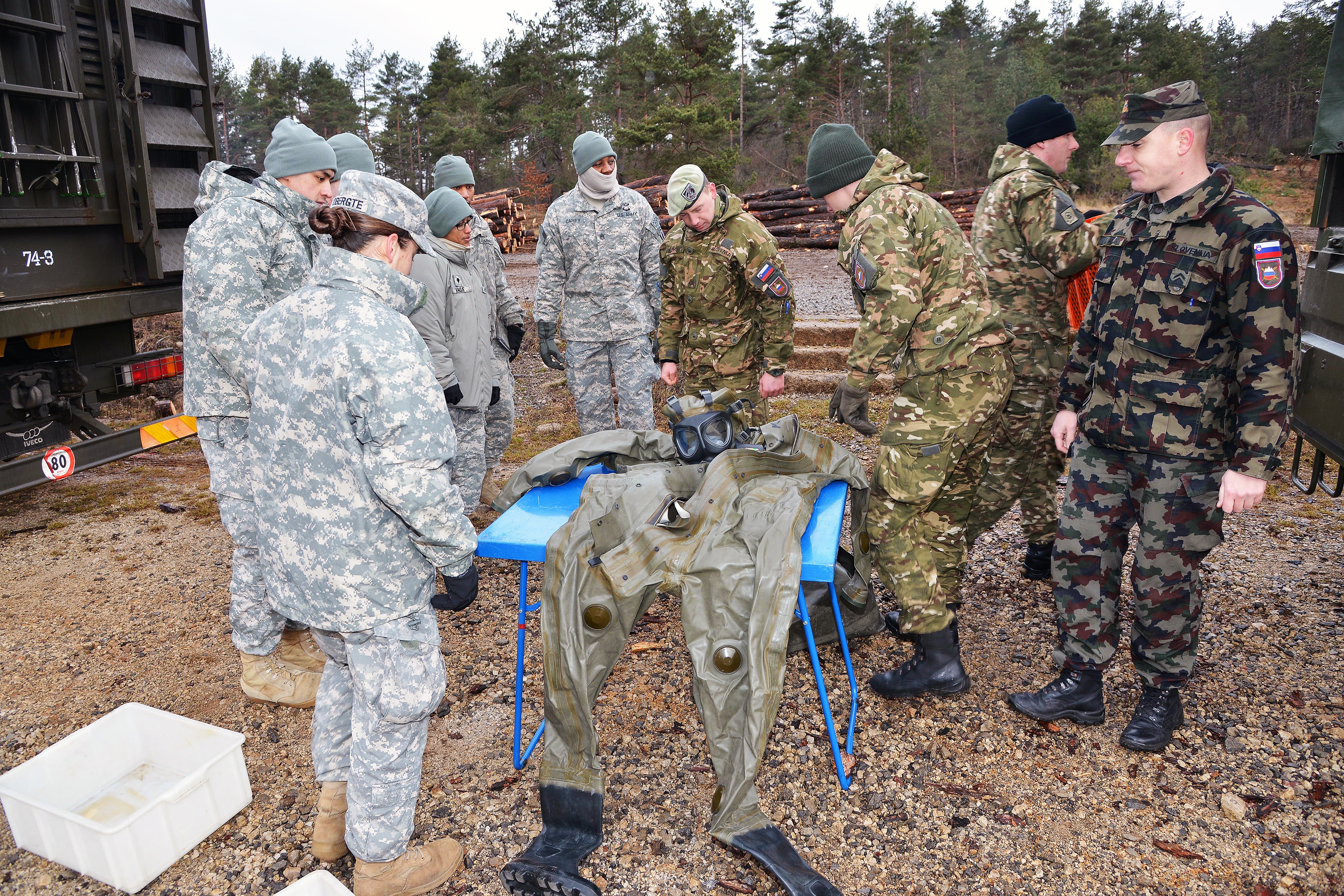 Slovenian soldiers show U.S. paratroopers a Slovenian protection suit ...