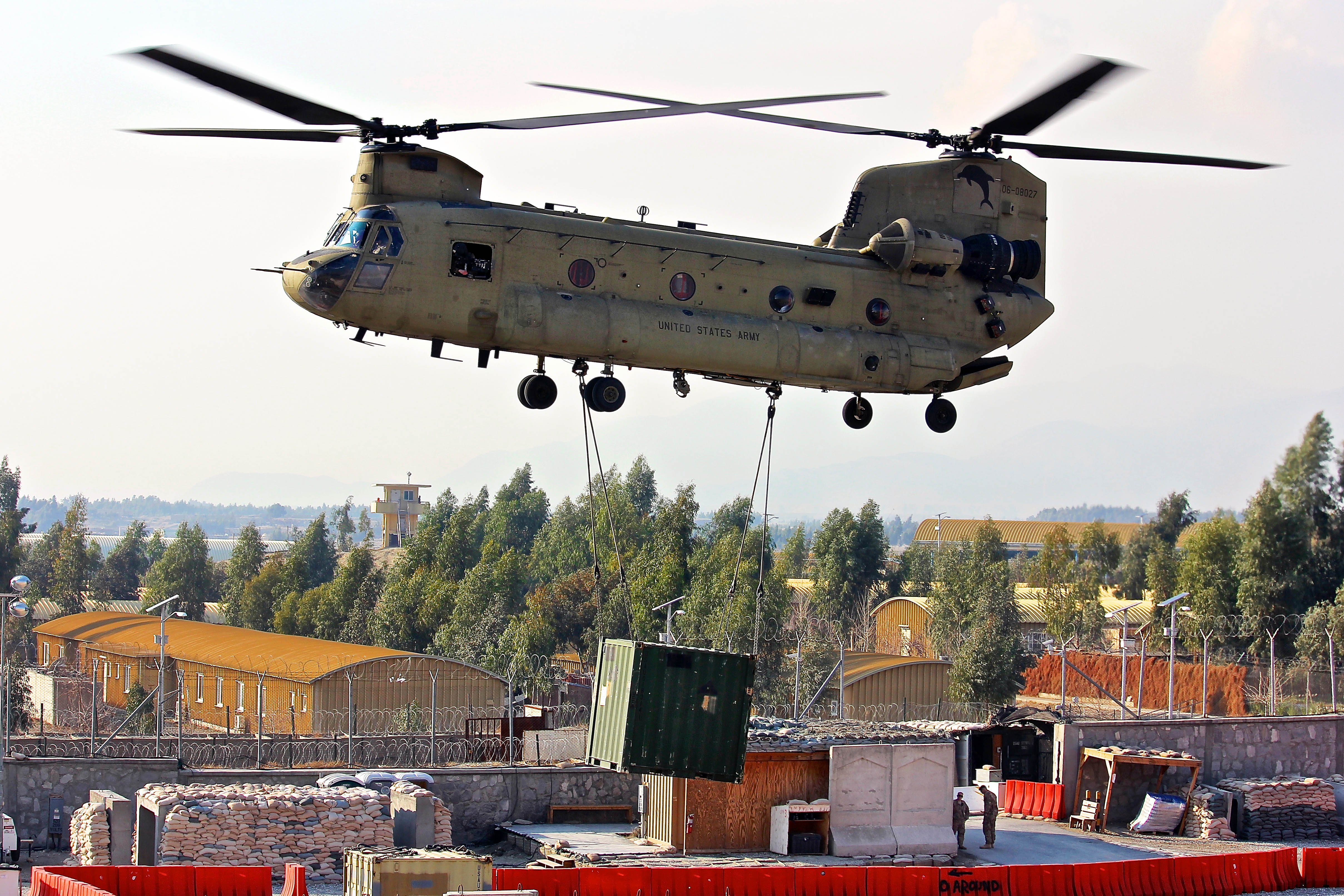 A CH-47 Chinook helicopter lifts off with a shipping container during ...