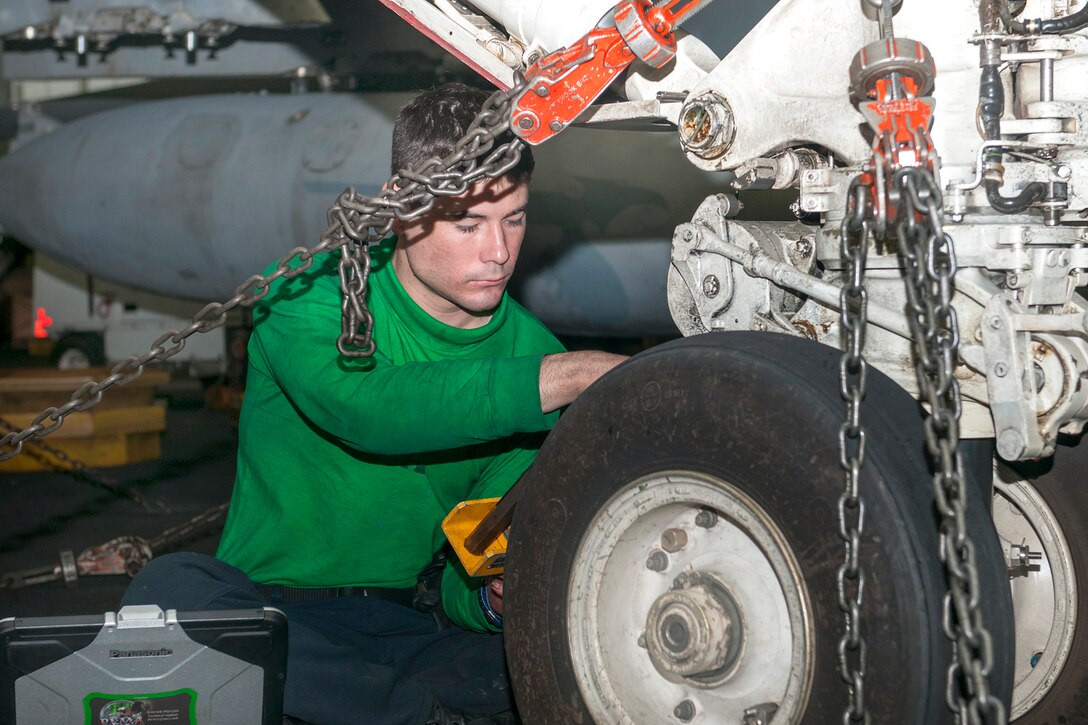 U.S. Navy Petty Officer 3rd Class Cameron Cabrera performs maintenance ...