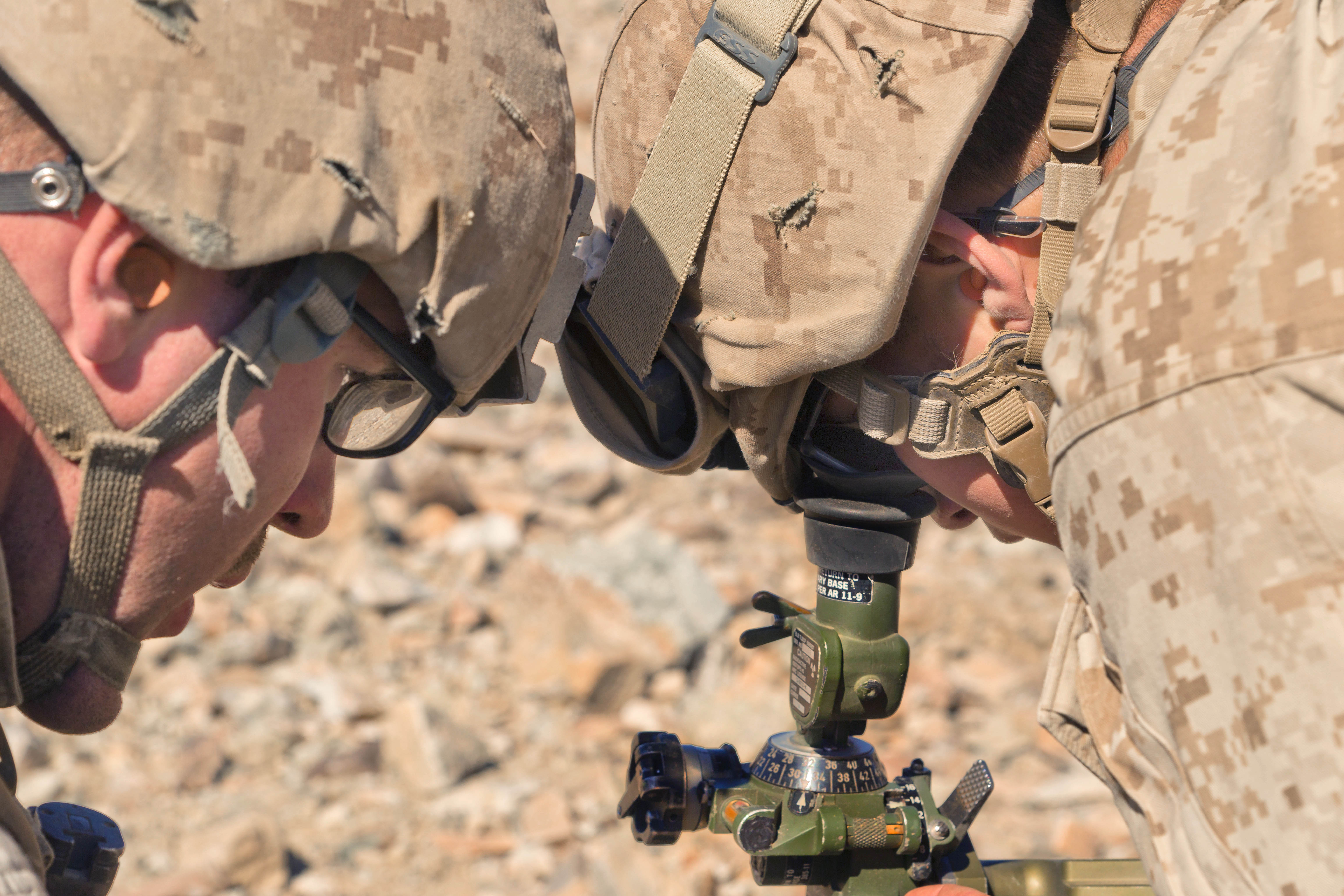 A Marine looks though the M64A1 sight unit on an M224 mortar system ...