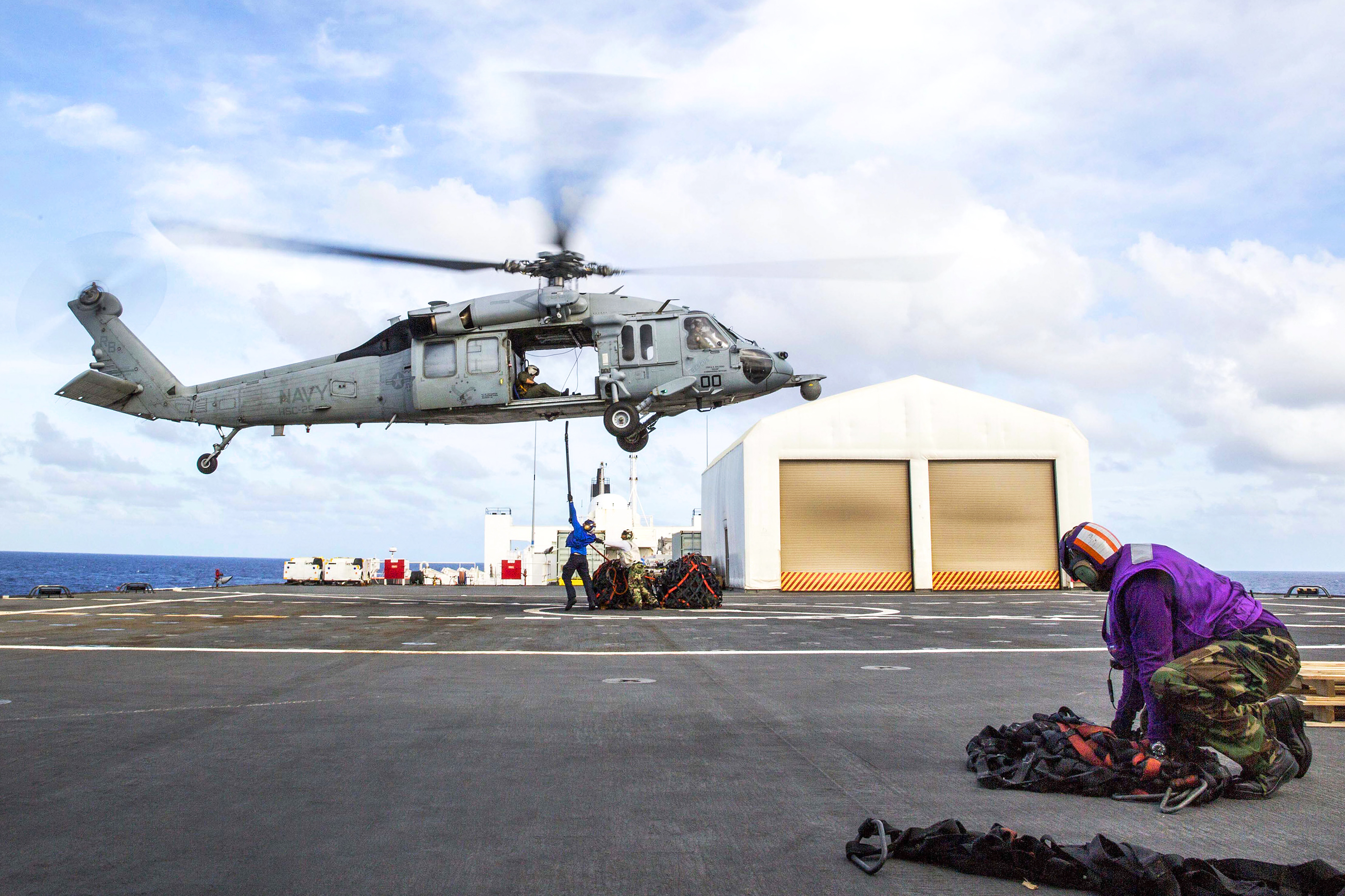 U.S. sailors on the flight deck of the hospital ship USNS Mercy secure ...
