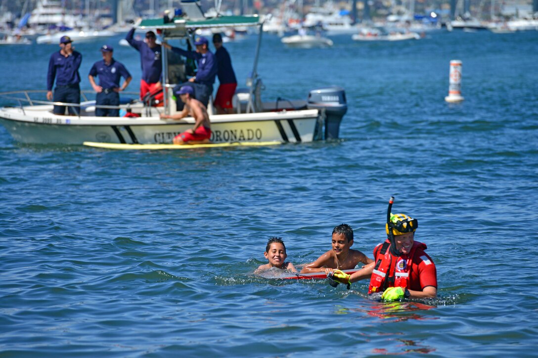 Coast Guard Petty Officer 2nd Class Ryan Pierce tows two children ...