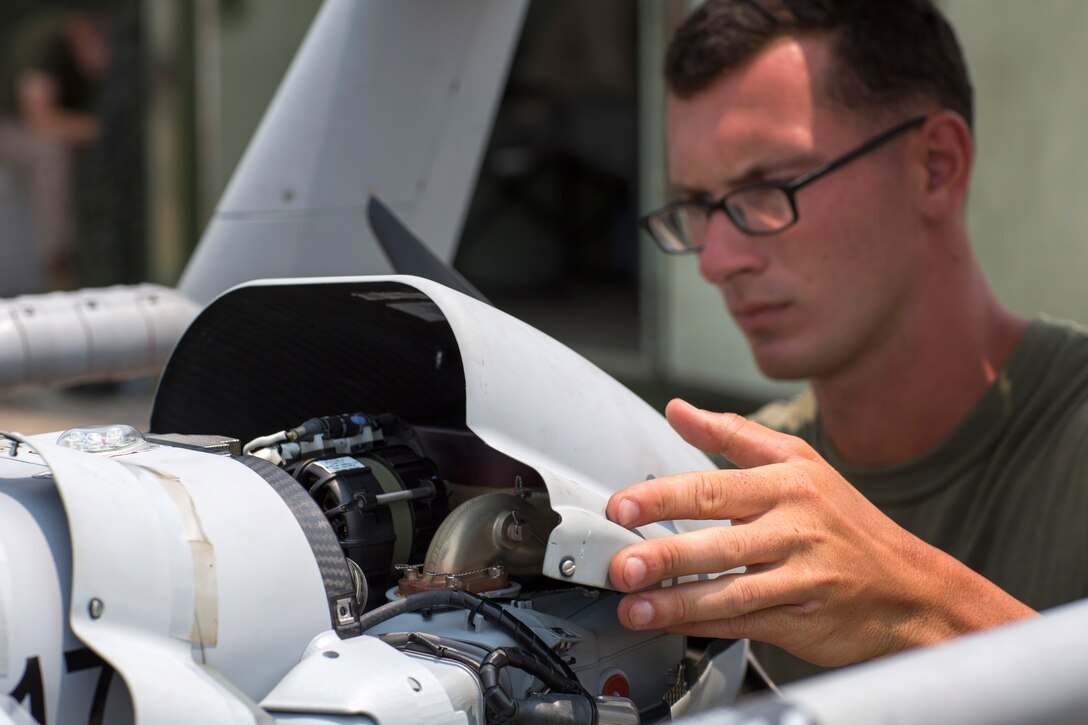 Marine Corps Cpl. John T. Commins performs a maintenance check on an RQ ...