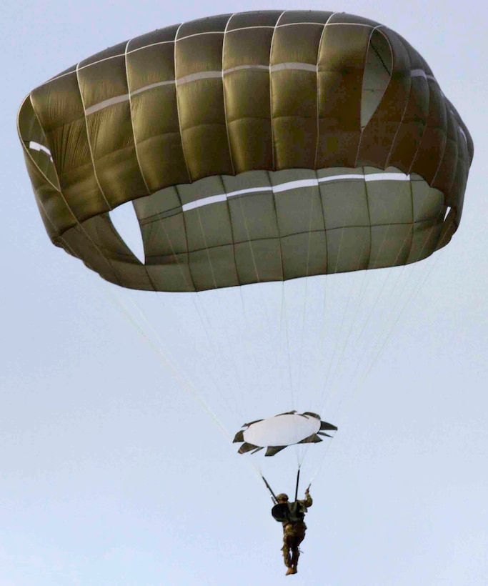 A U.S. paratrooper using a T-11 parachute descends on the drop zone ...