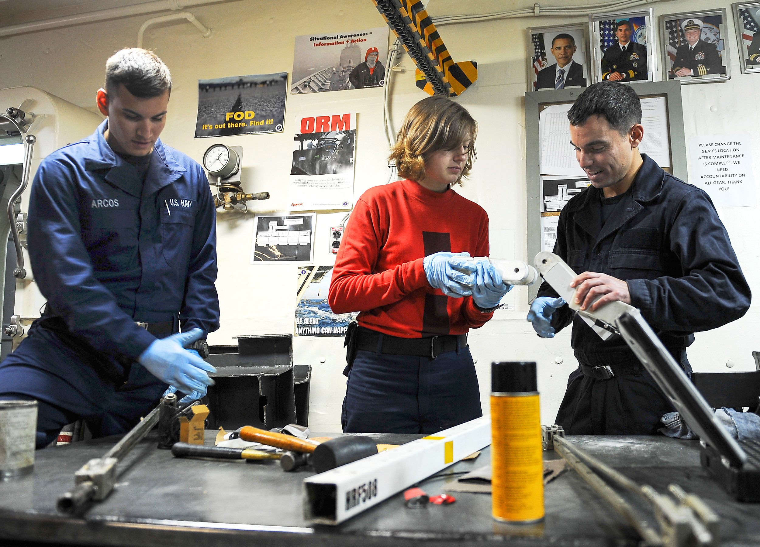 U.S. Navy sailors repair weapons support equipment aboard the aircraft ...